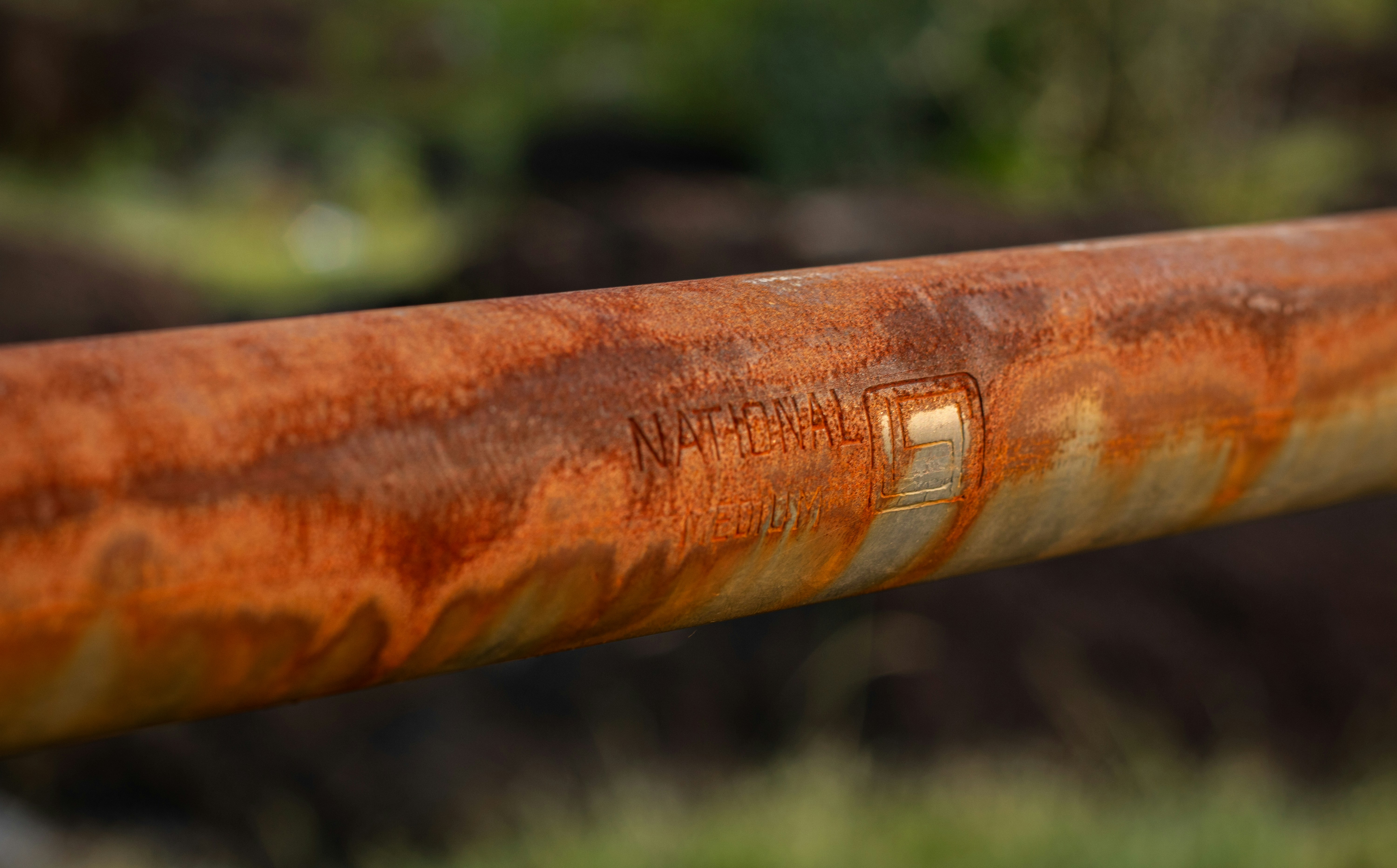 Rusted Rail Underlying Time: Weathered Markings on a Bar