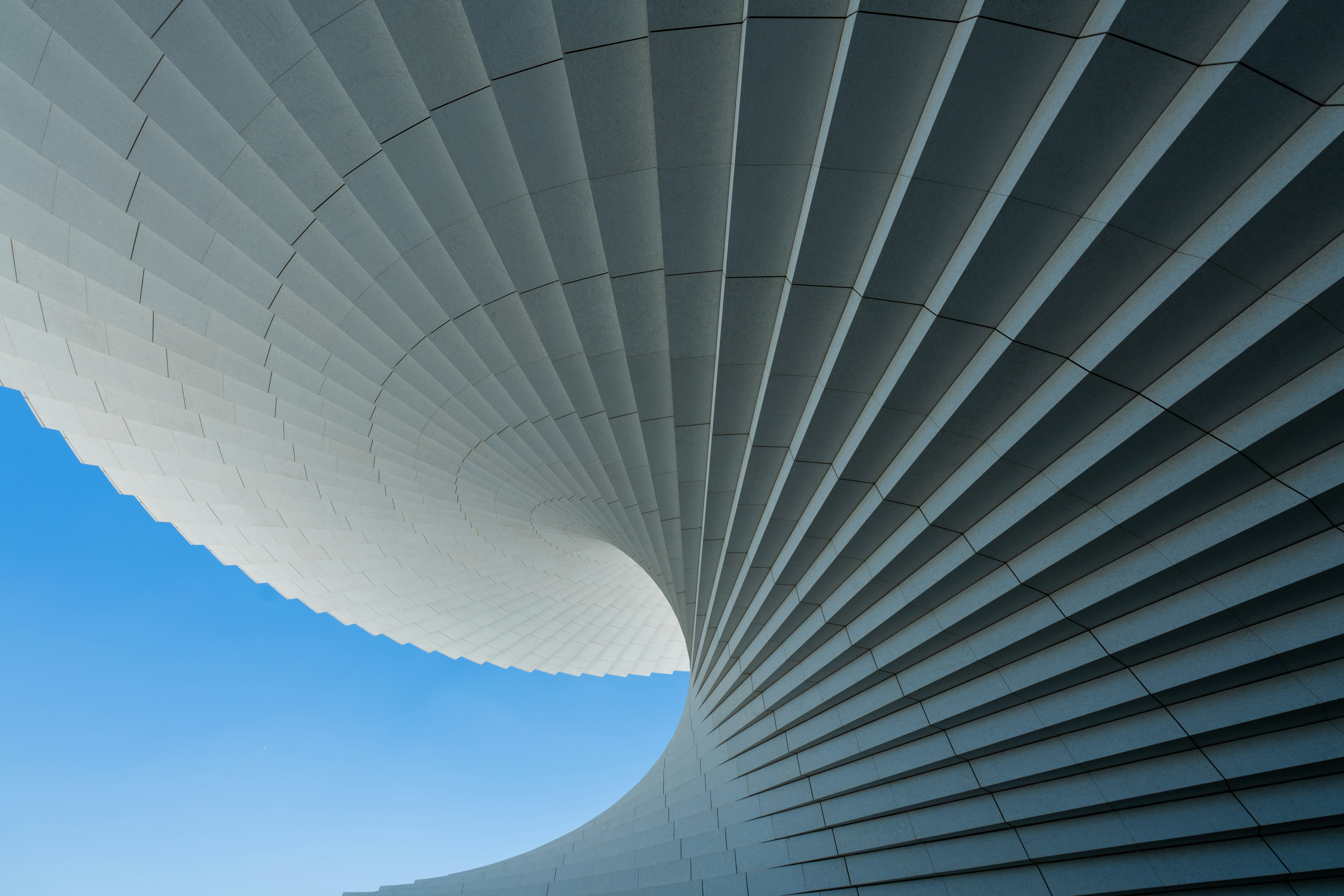 Curved Titanium Loft: An Arching Tunnel of Light and Shadow