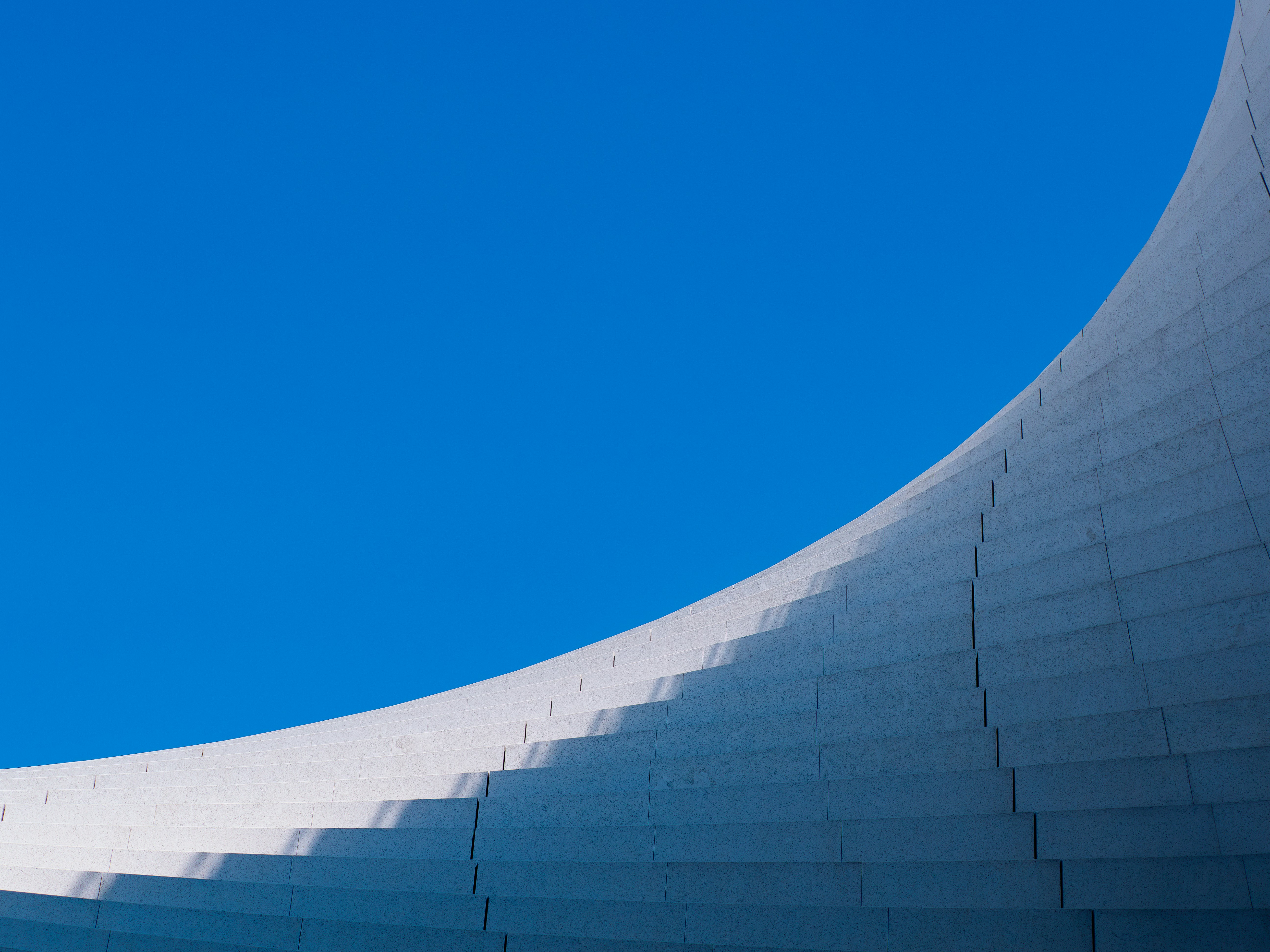 Arc of Silence: A Sky-White Curve Against a Cerulean Field