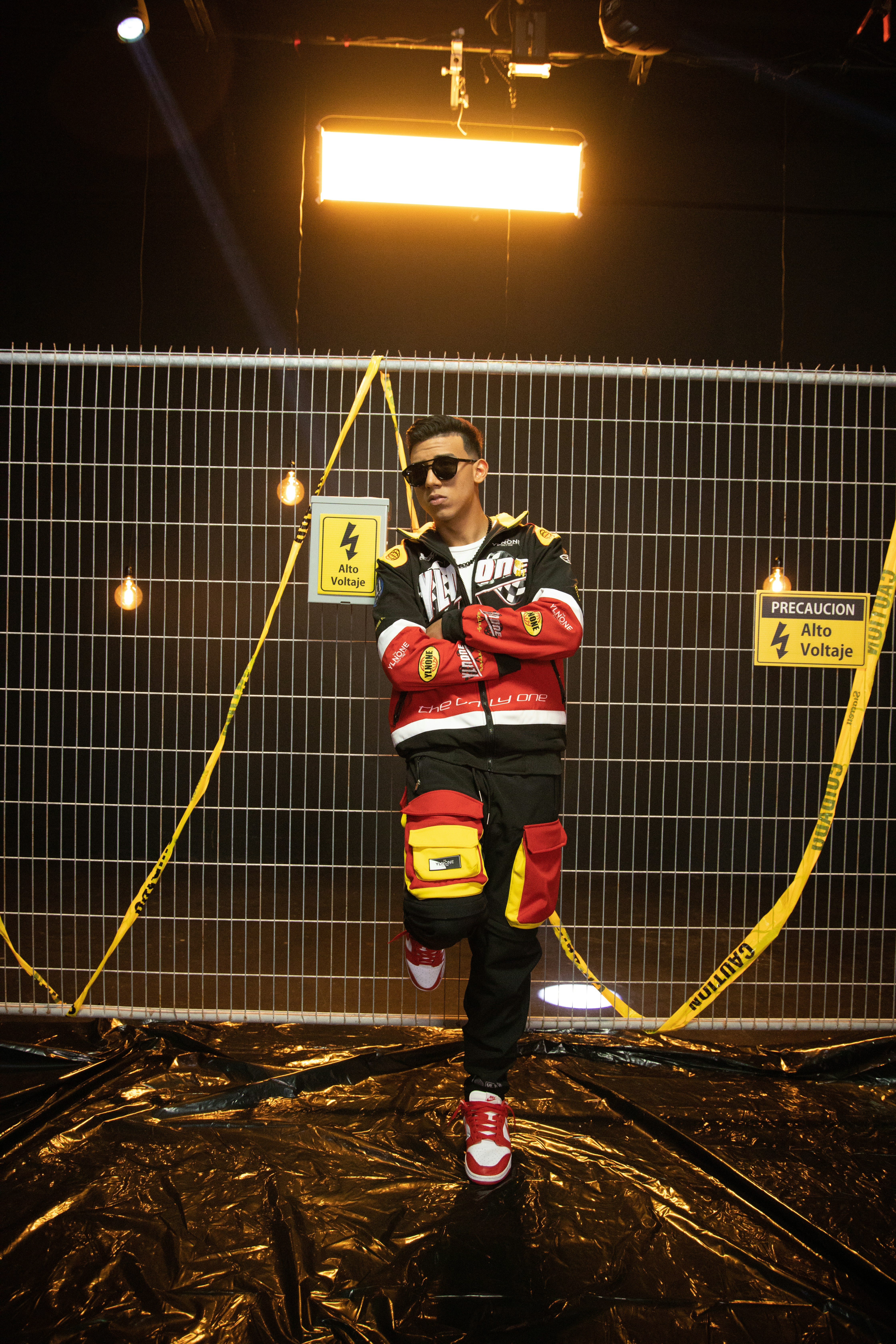 Electric Neon: A confident rider strikes a pose inside a warning-lit barriers cage