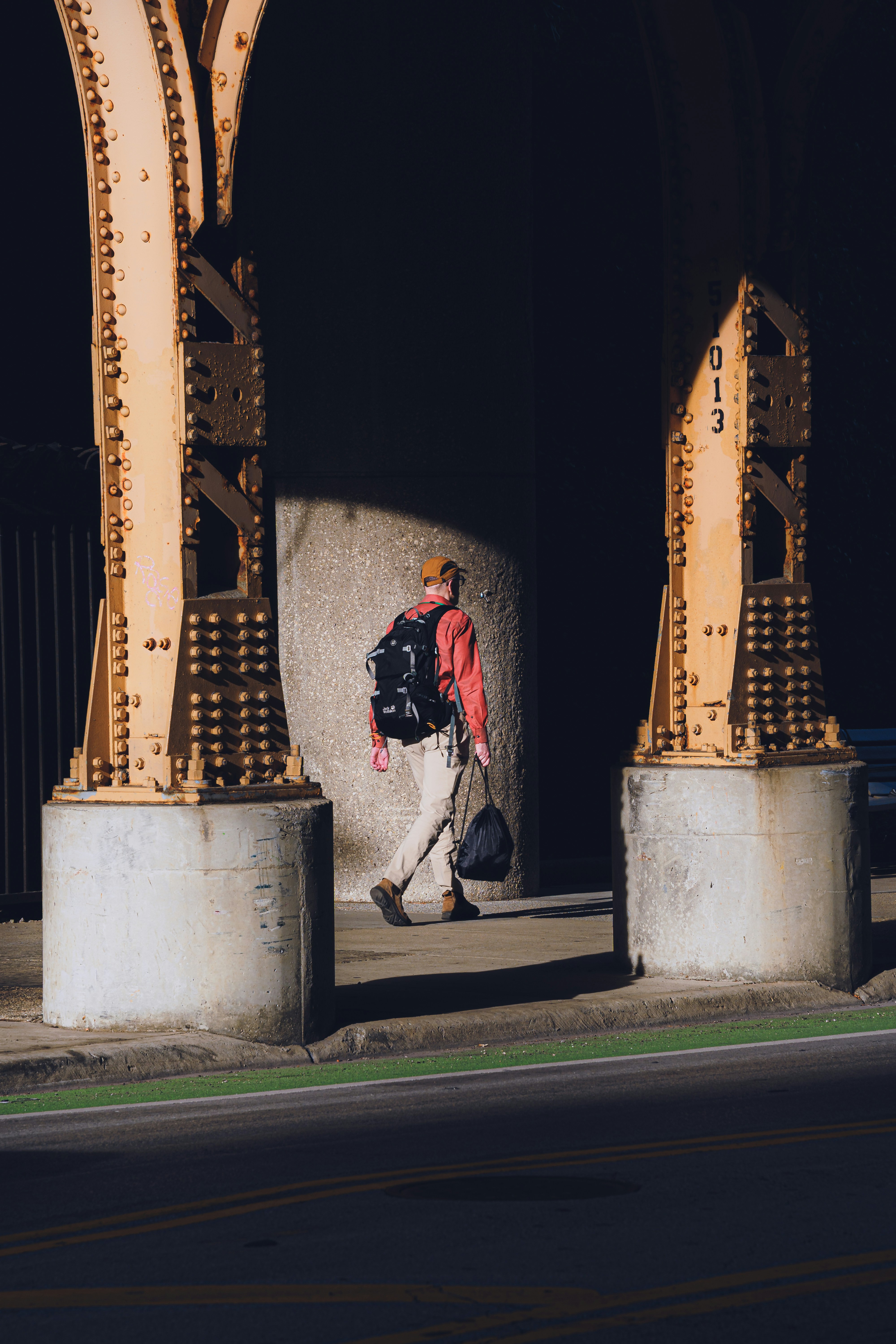 Traveler in a Red Jacket Under the Golden Bridge Trusses
