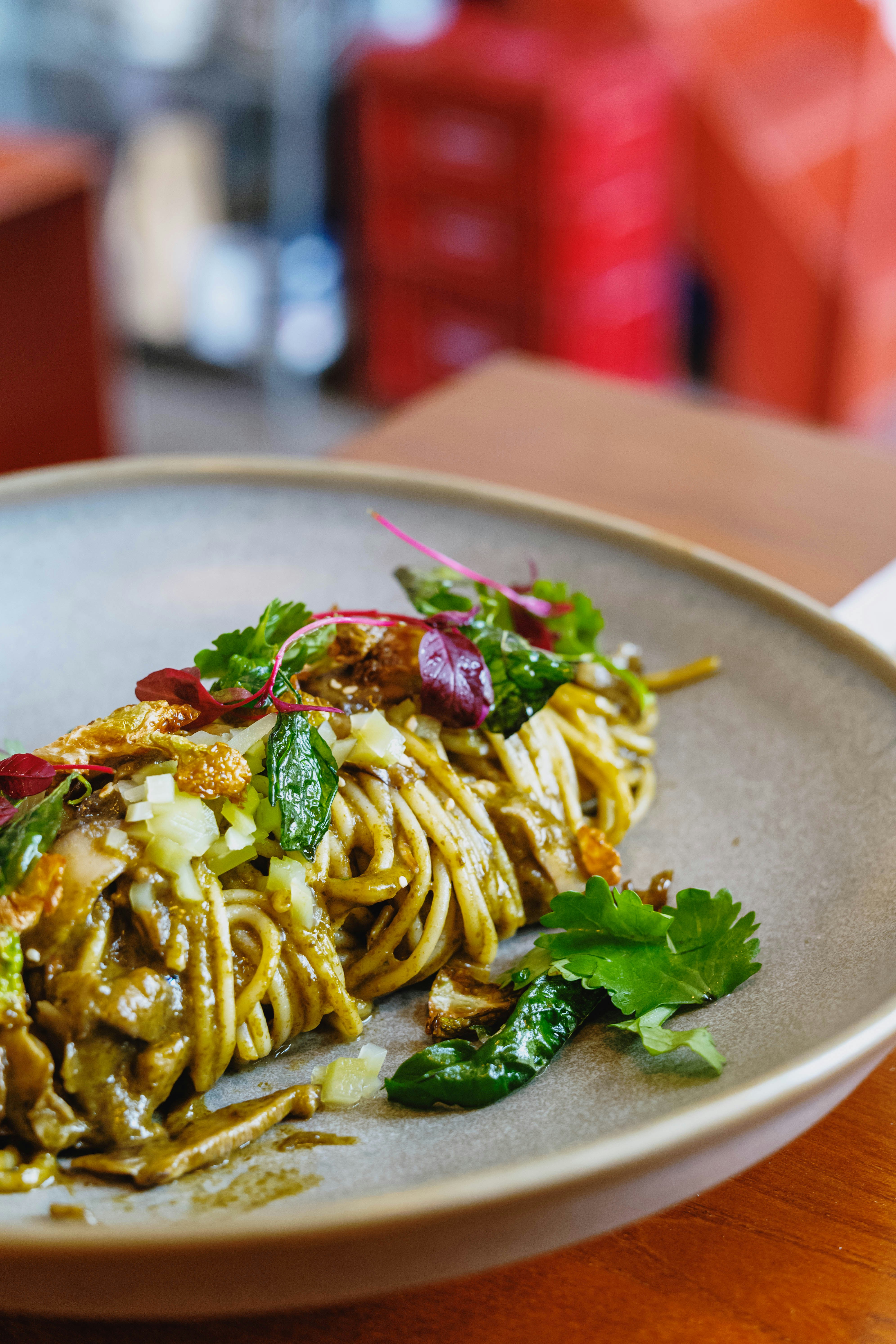 Herbed Pasta Convergence: A Plate of Savory Noodles in a Cozy Eatery