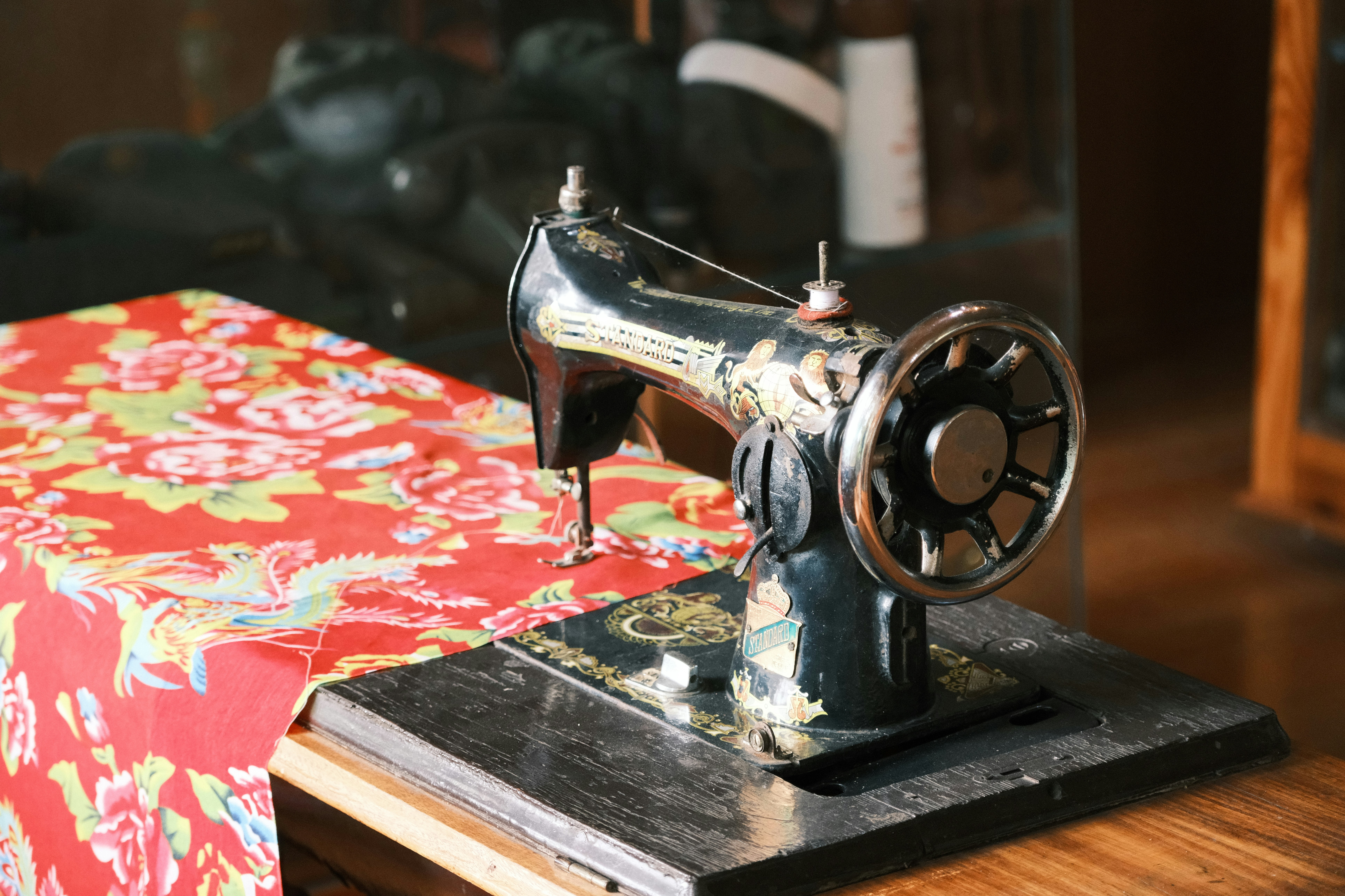 Sunlit Vintage Singer: A Thread of Time on a Floral Tablecloth