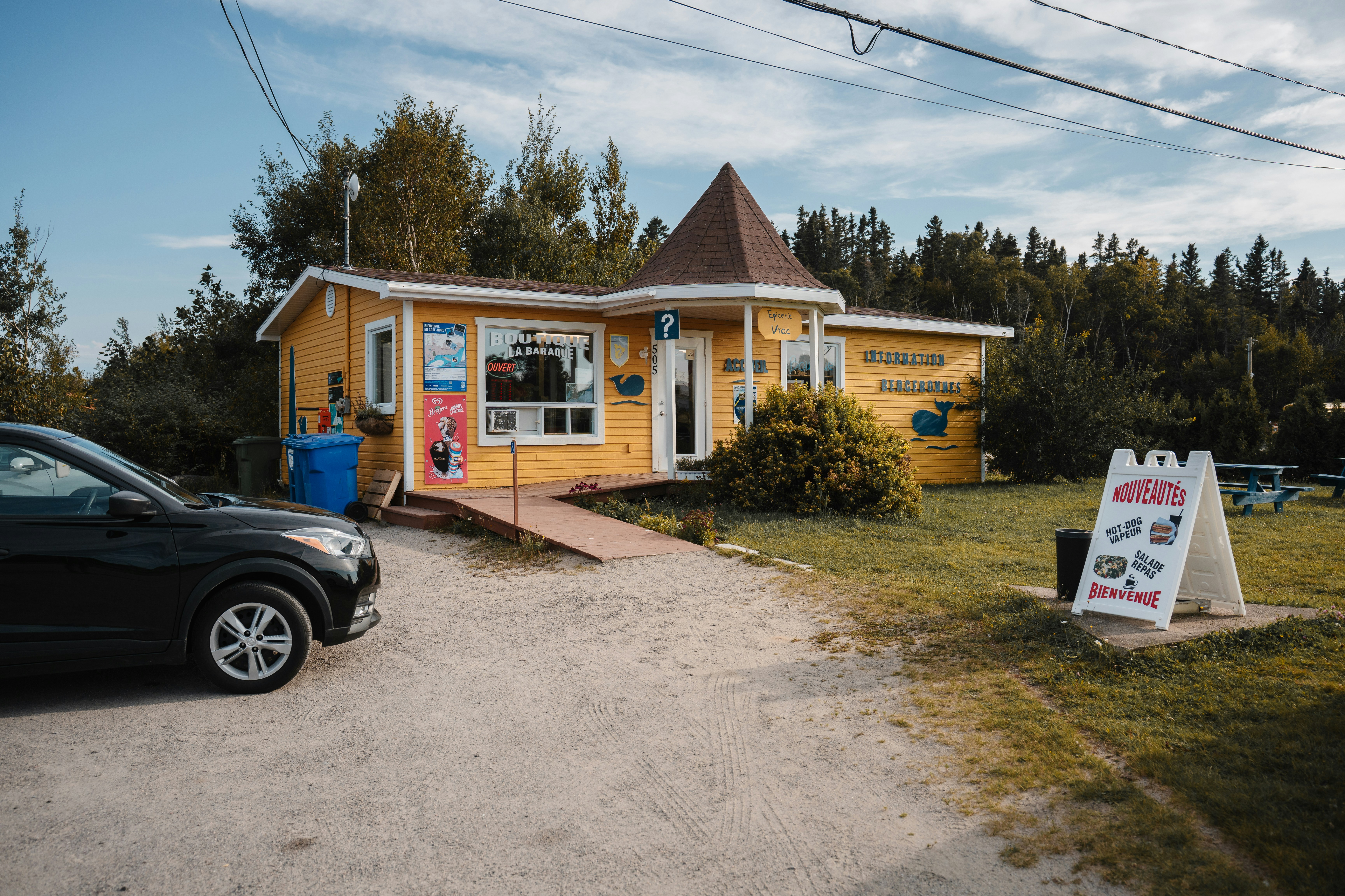 Sunny yellow kiosk by a quiet road, inviting visitors to the dessert stand
