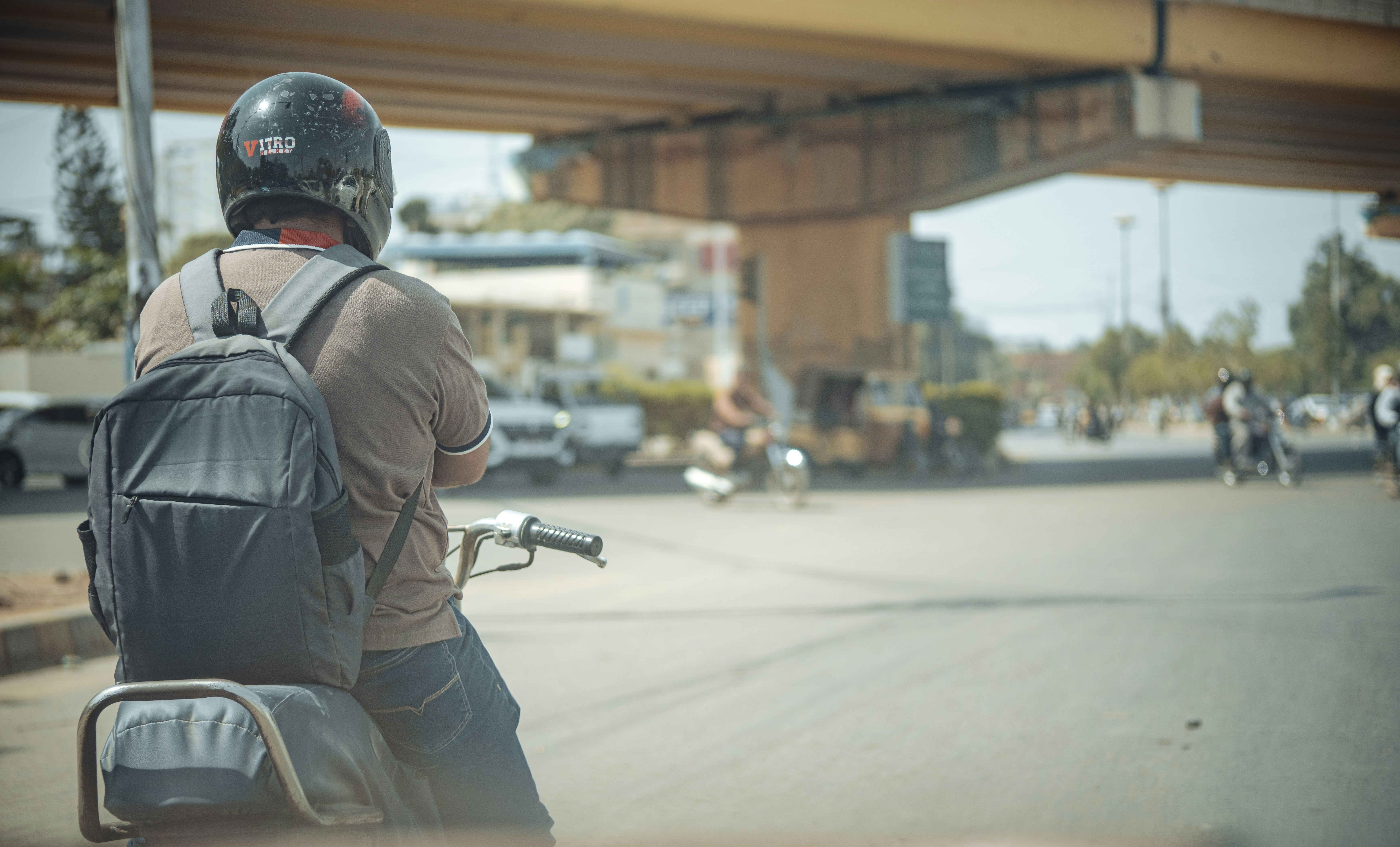 Backpacker on a Quiet City Street: Helmet, Backpack, and Handlebars