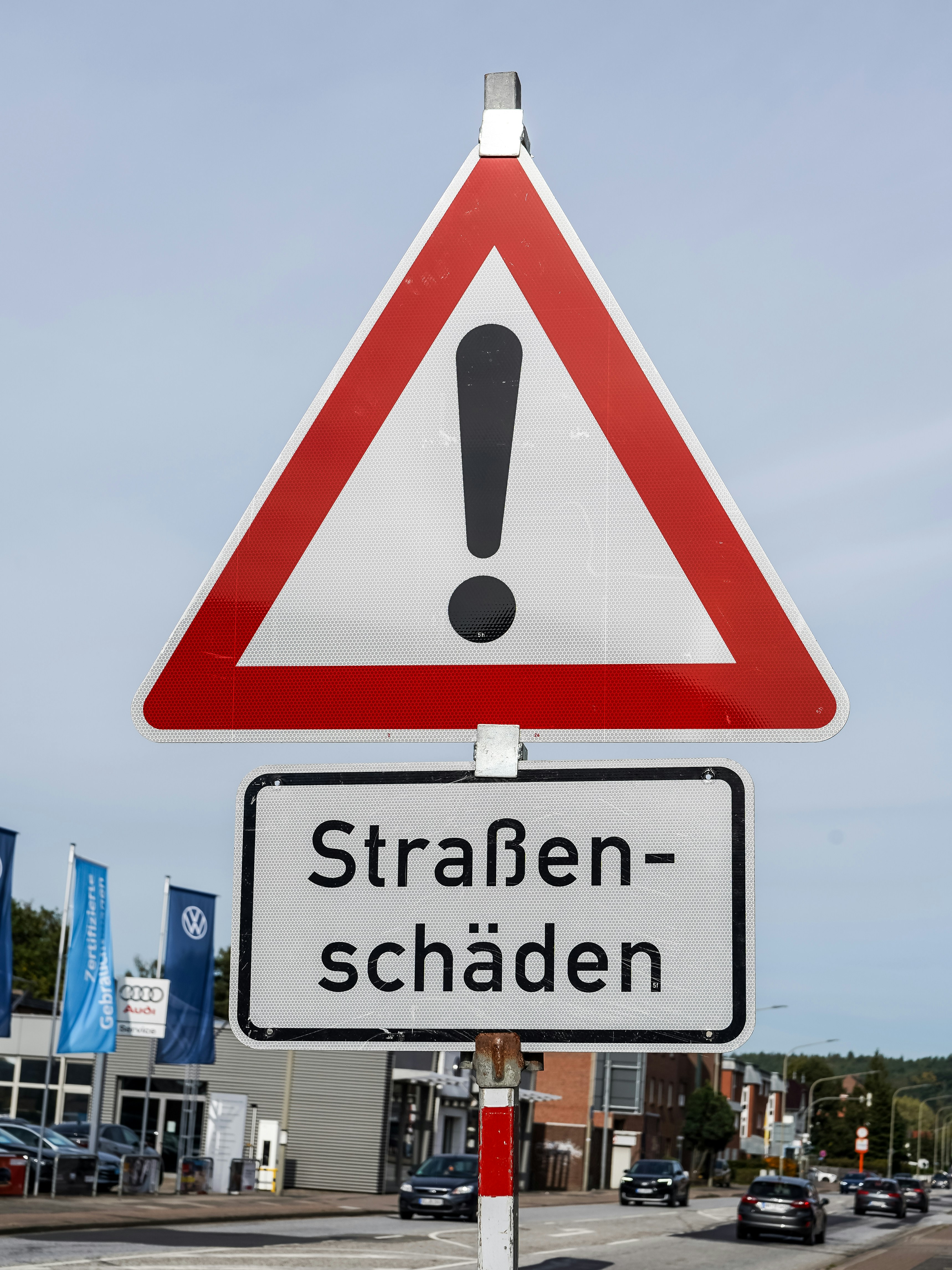 Warning Sign Over a Busy German Street: Caution in Focus