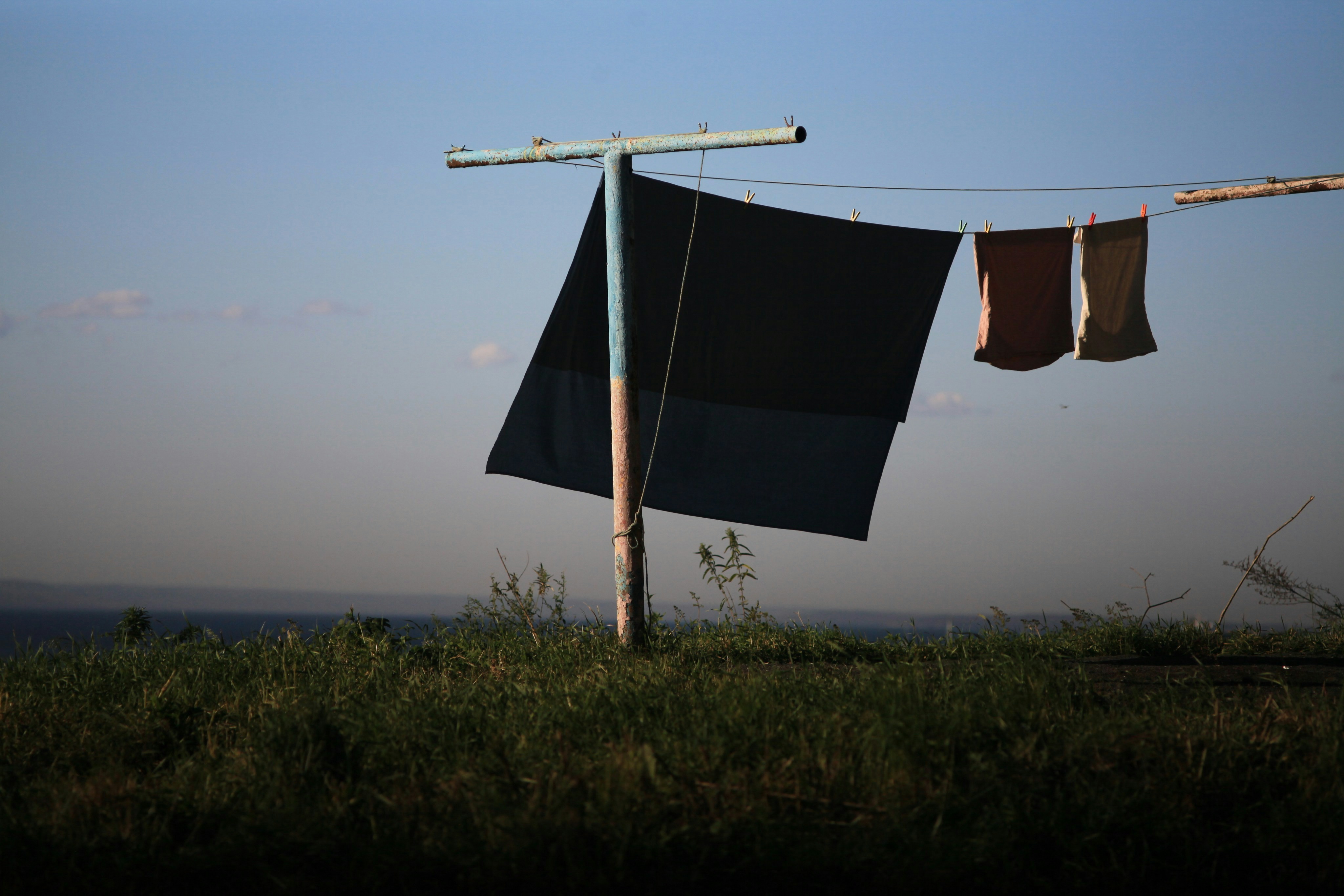 Clothesline Sentinel: A Lone Tarp Draped Over a Simple Hanger