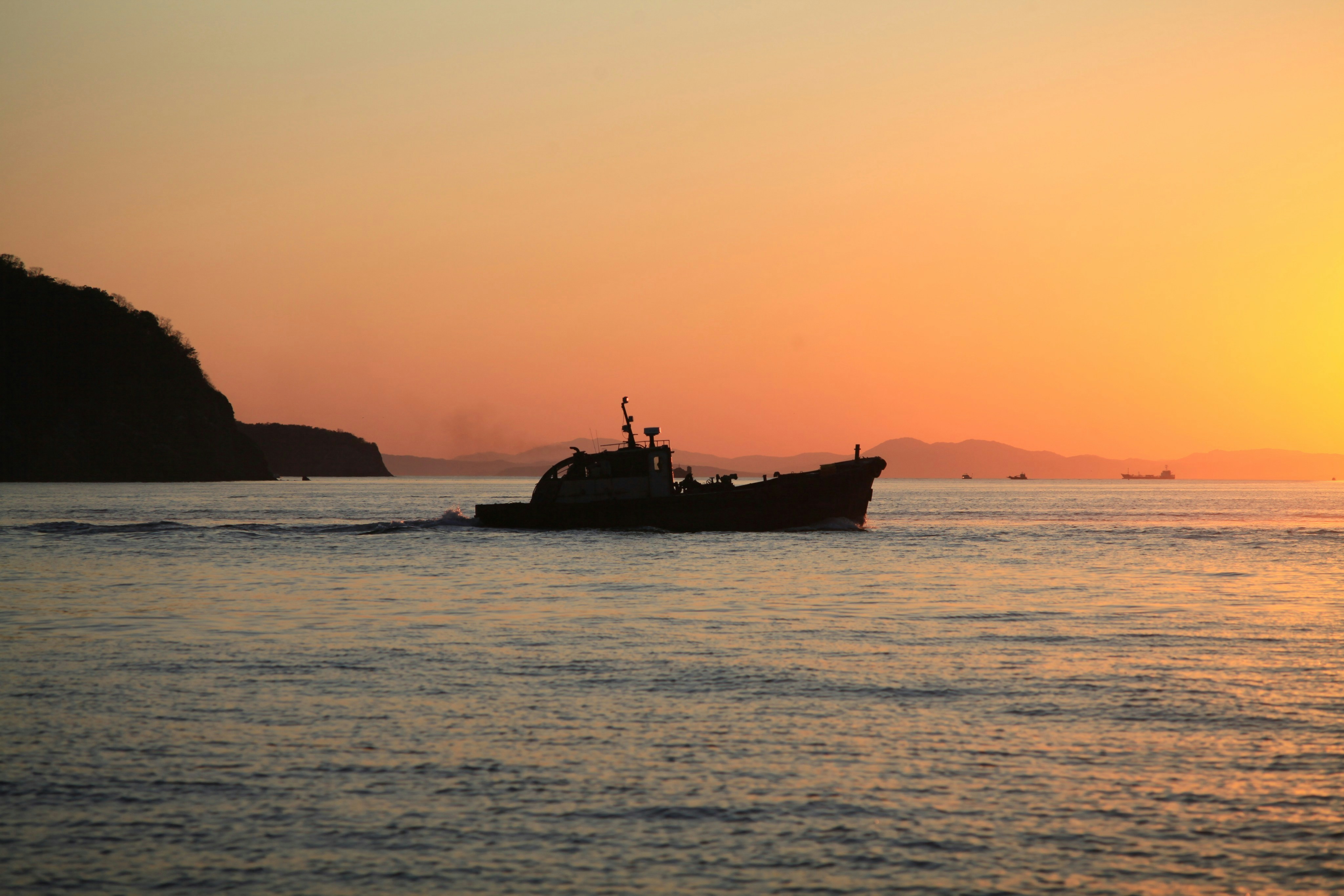 Silhouette Vessel at Sunset Horizon