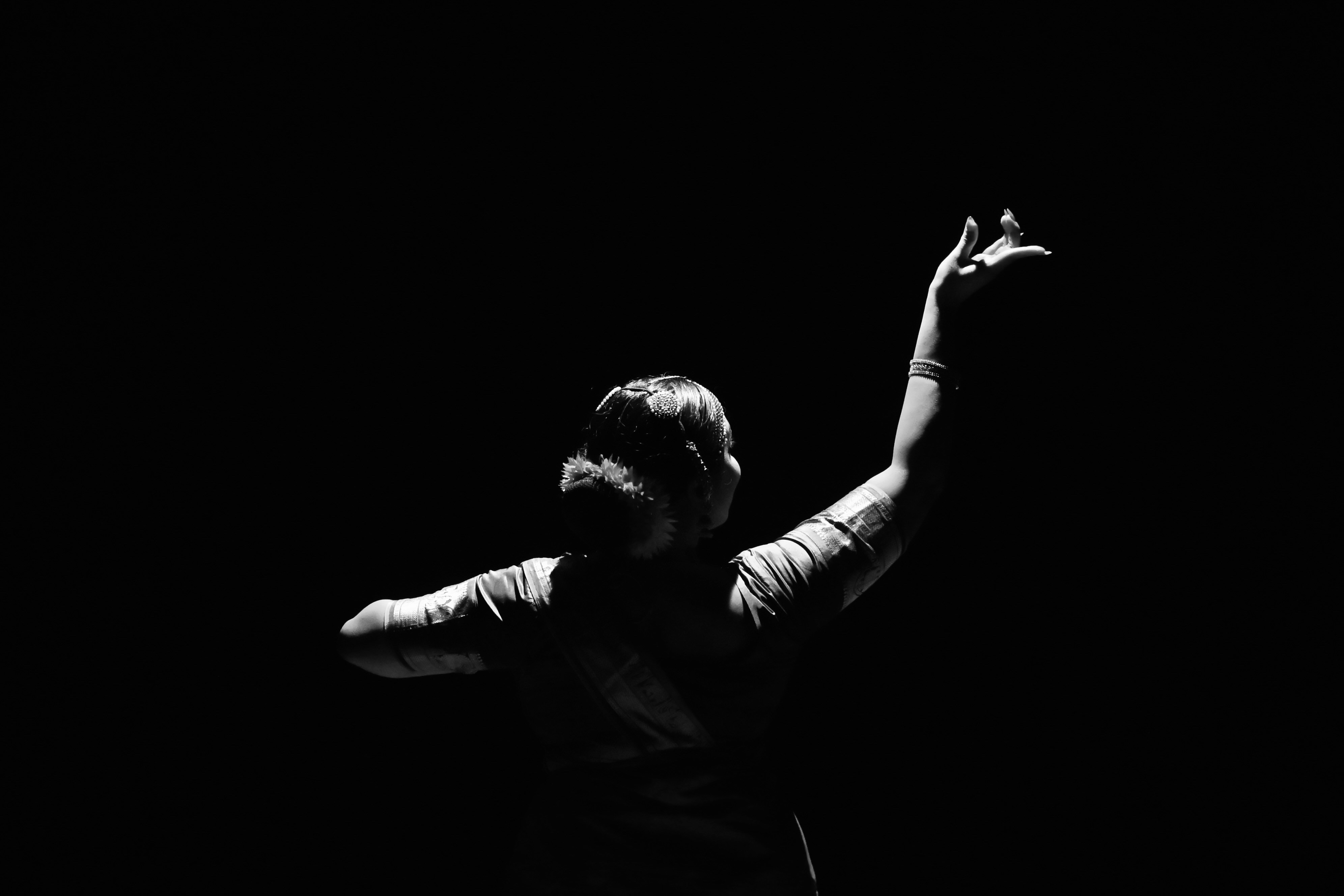 Silhouette of a Celebrant: A Raised Hand in Nightfall