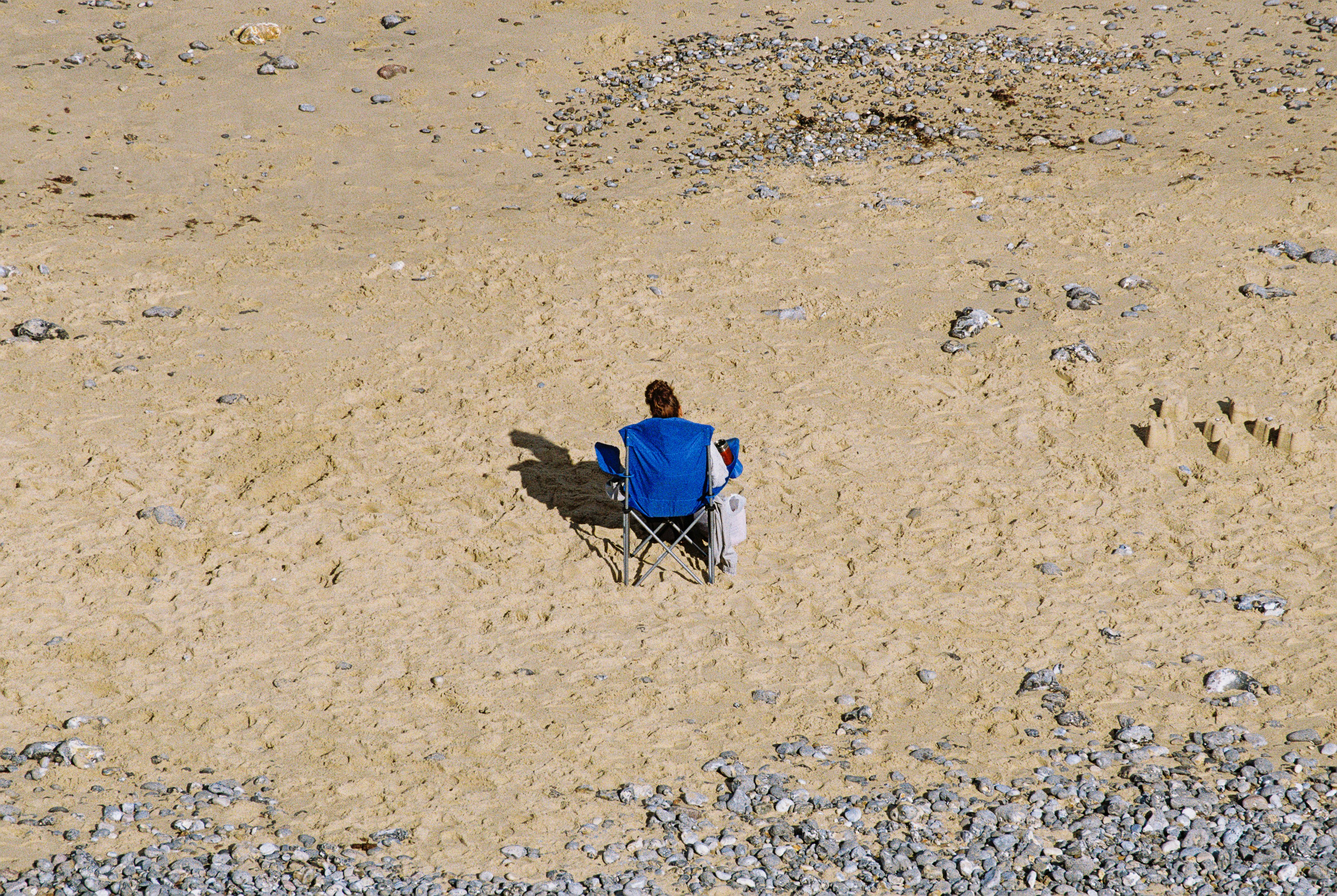 Solitary Spotlight: A Beachgoer in Quiet Sand