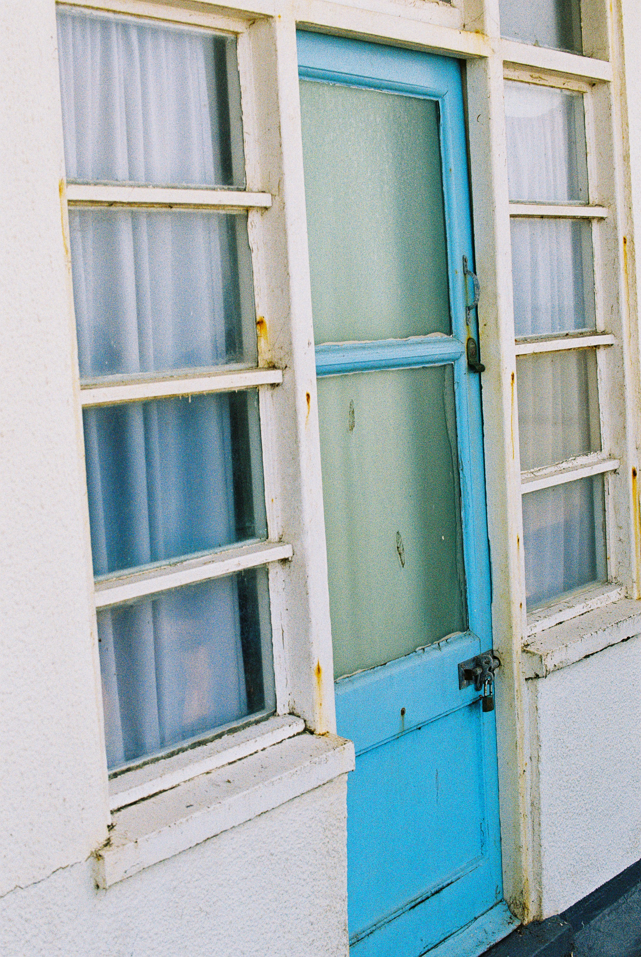 Azure Doorway: A Weathered Frame of Blues and Quiet Windows