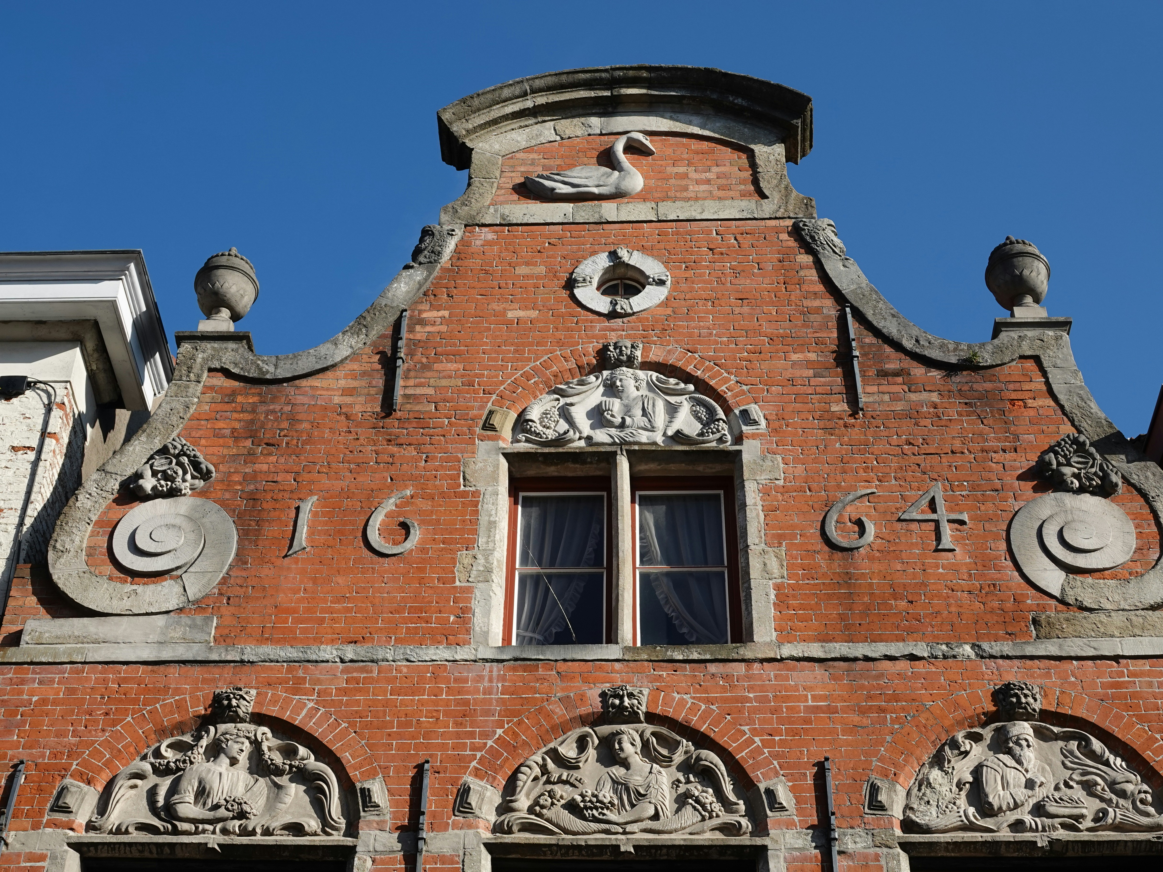 Brick Gables and Sculpted Crowns: A Dutch Revival Facade Under a Clear Sky