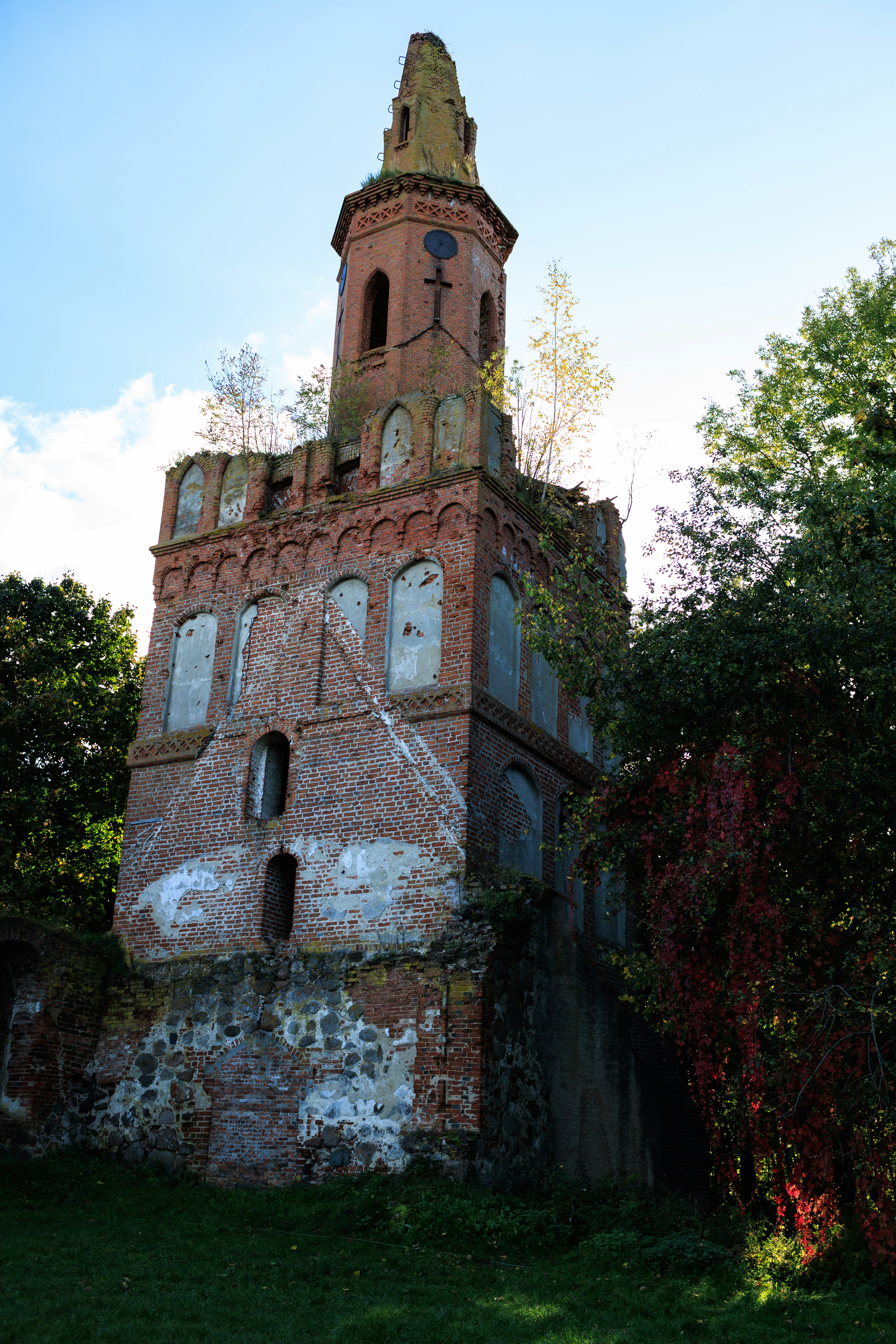 Ruined brick tower rising from shadowed grounds