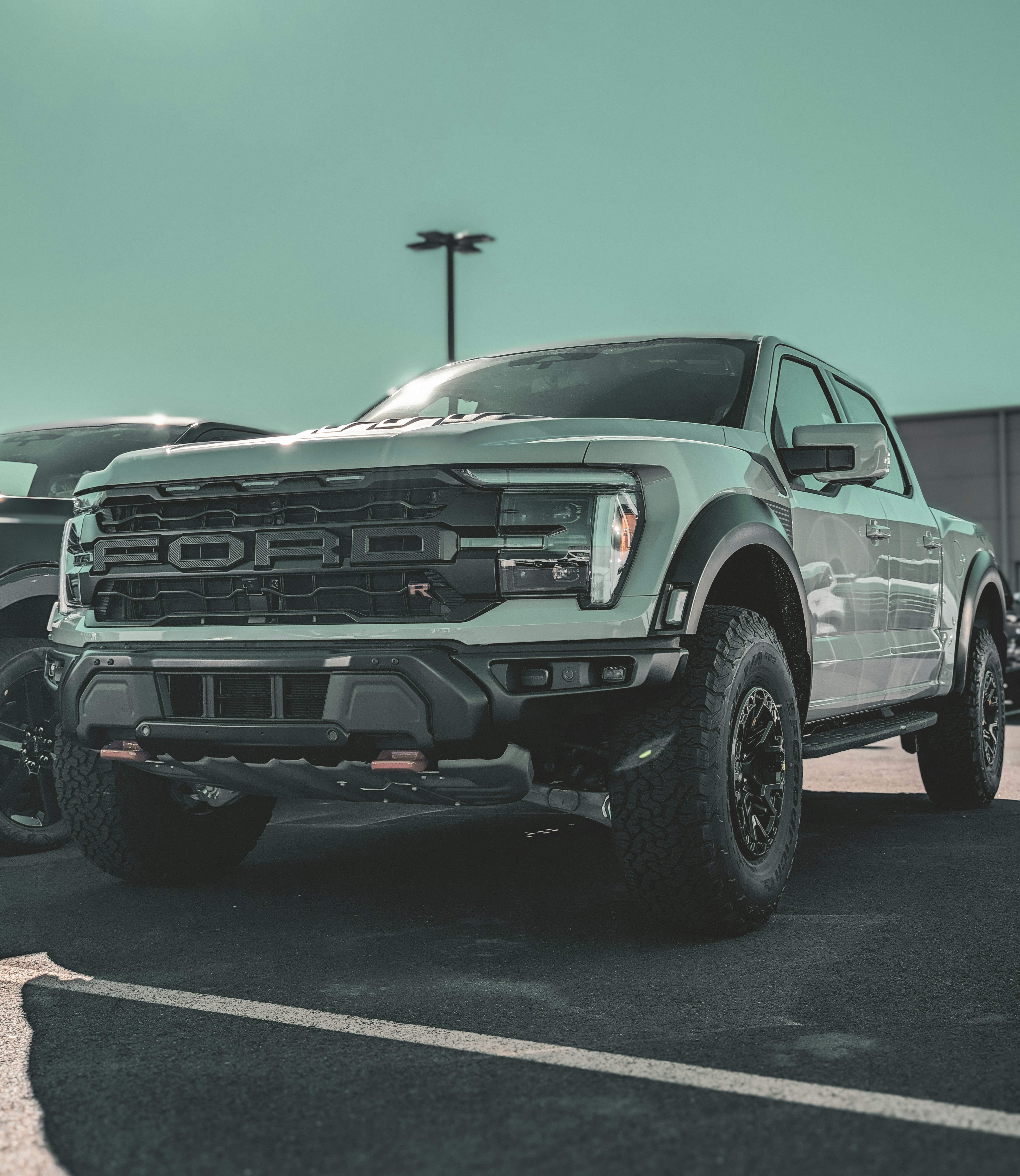 Raised in the Spotlight: a bold Ford Raptor under the dealership sun