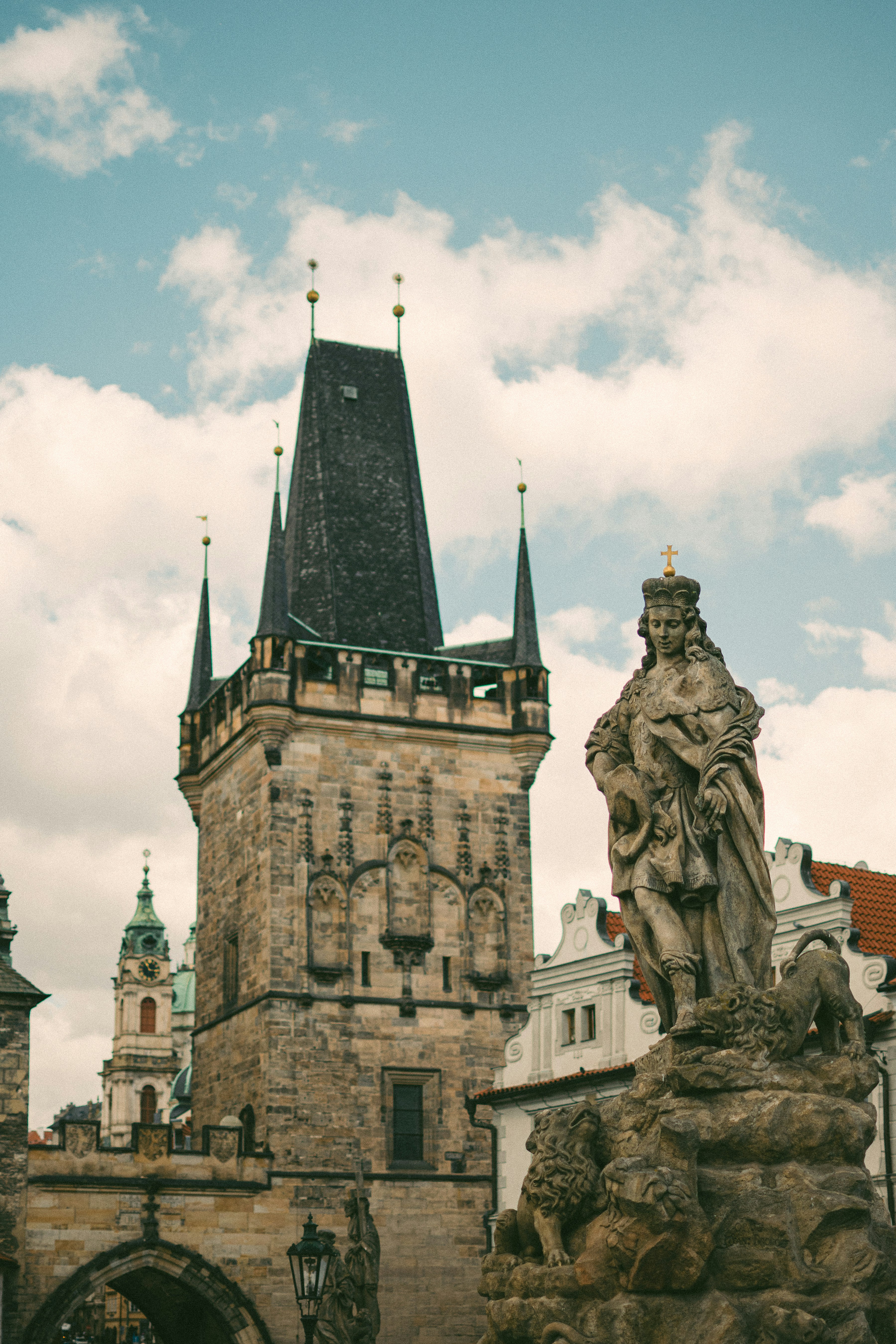 Gothic Tower and statue against a Prague-blue sky