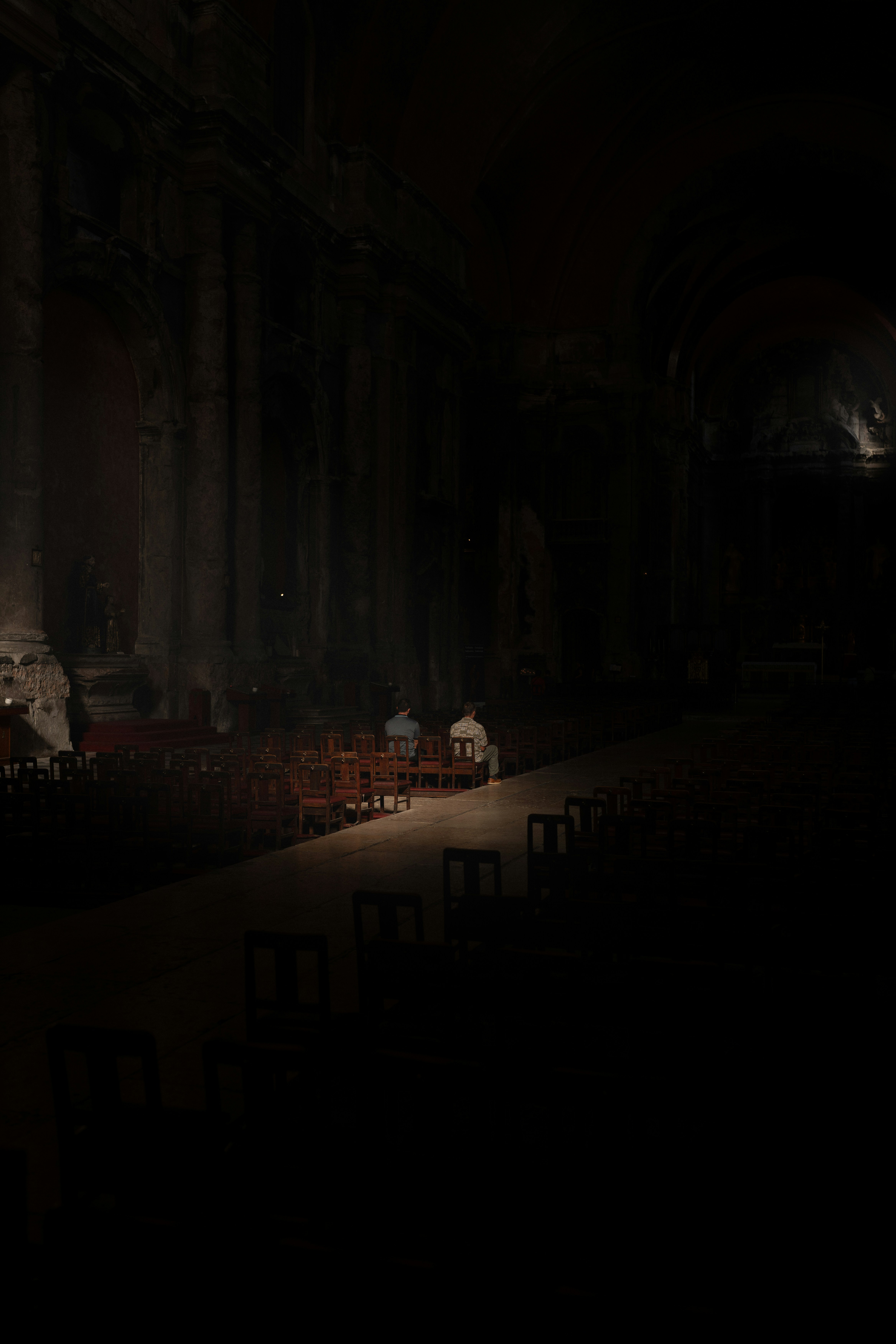 Spotlit Congregation in a Quiet Cathedral Aisle