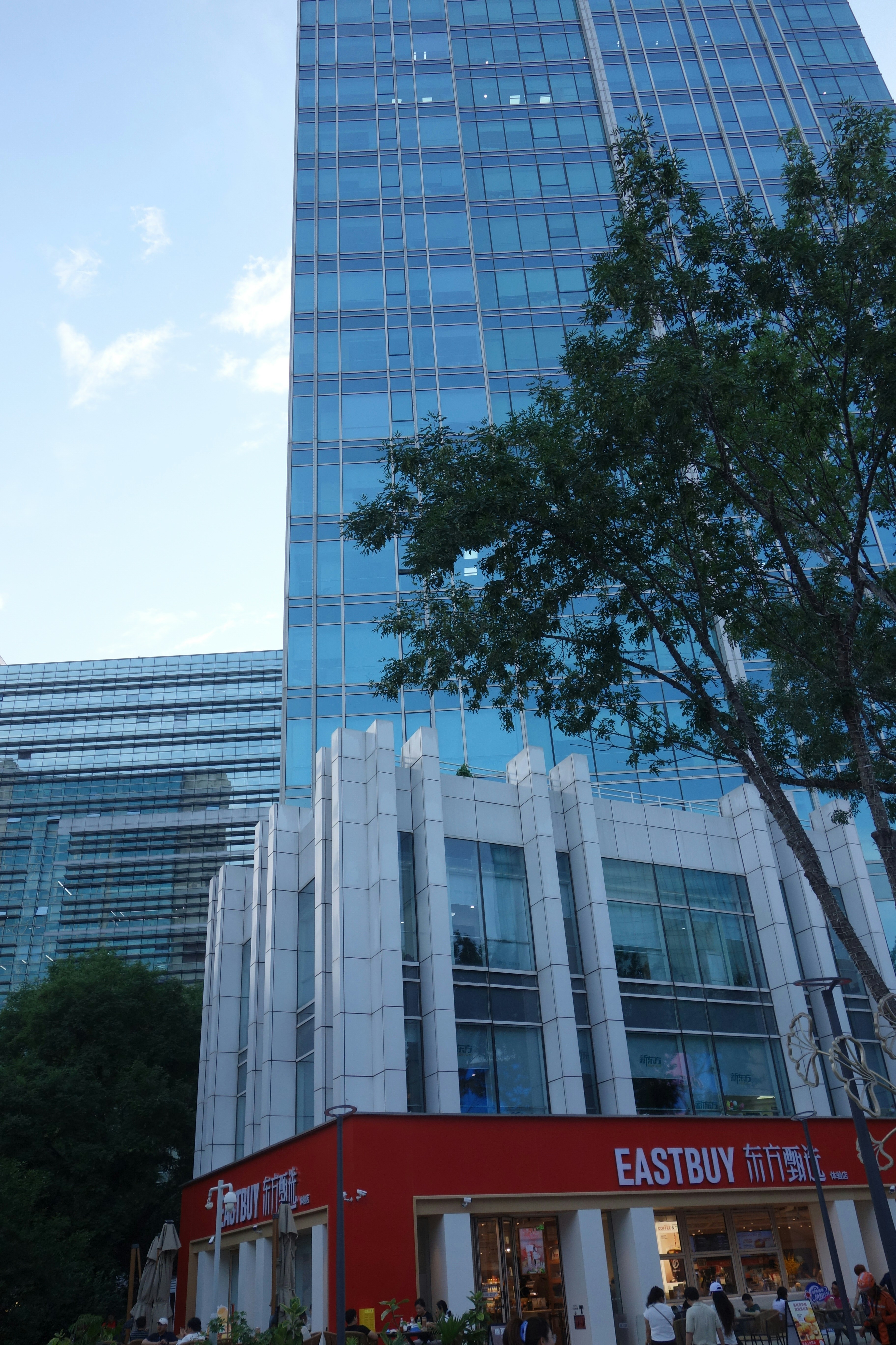 Glass Tower Reflections and Red Shopfront in Urban Dawn