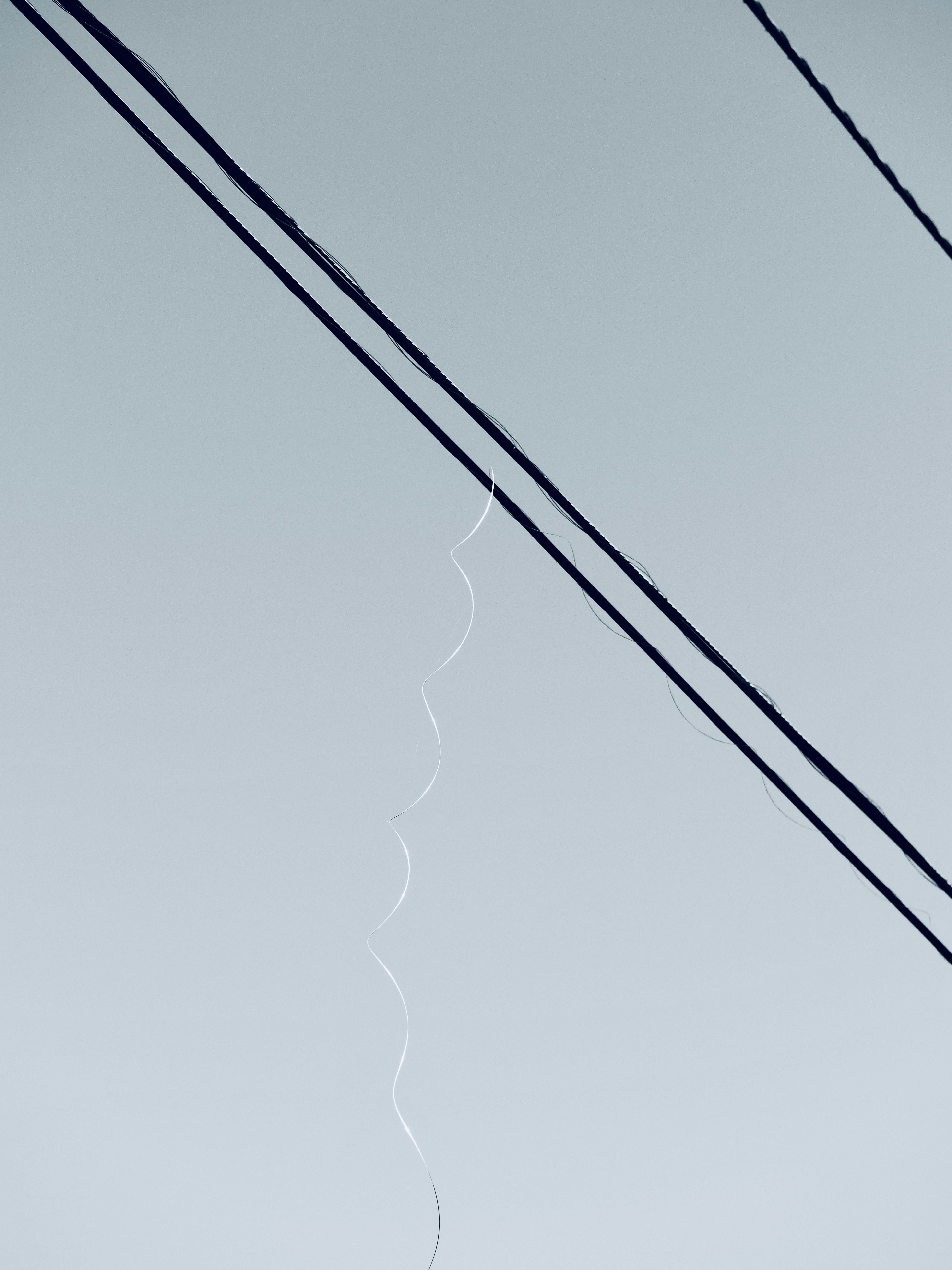 Ghostly Wire Veil Across a Clear Sky