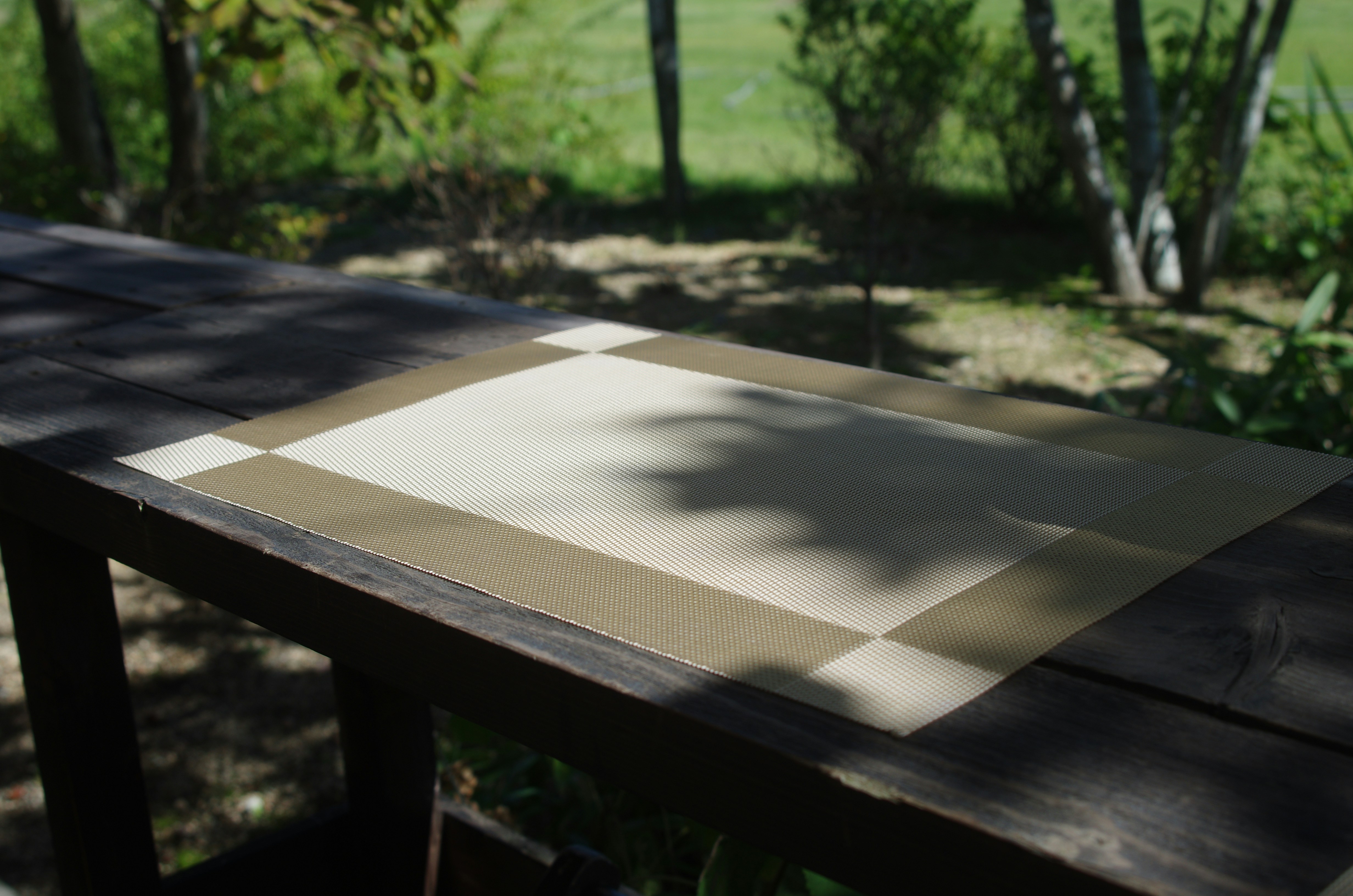 Sunlit Veranda: Geometric Shadows on a Wooden Table Runner