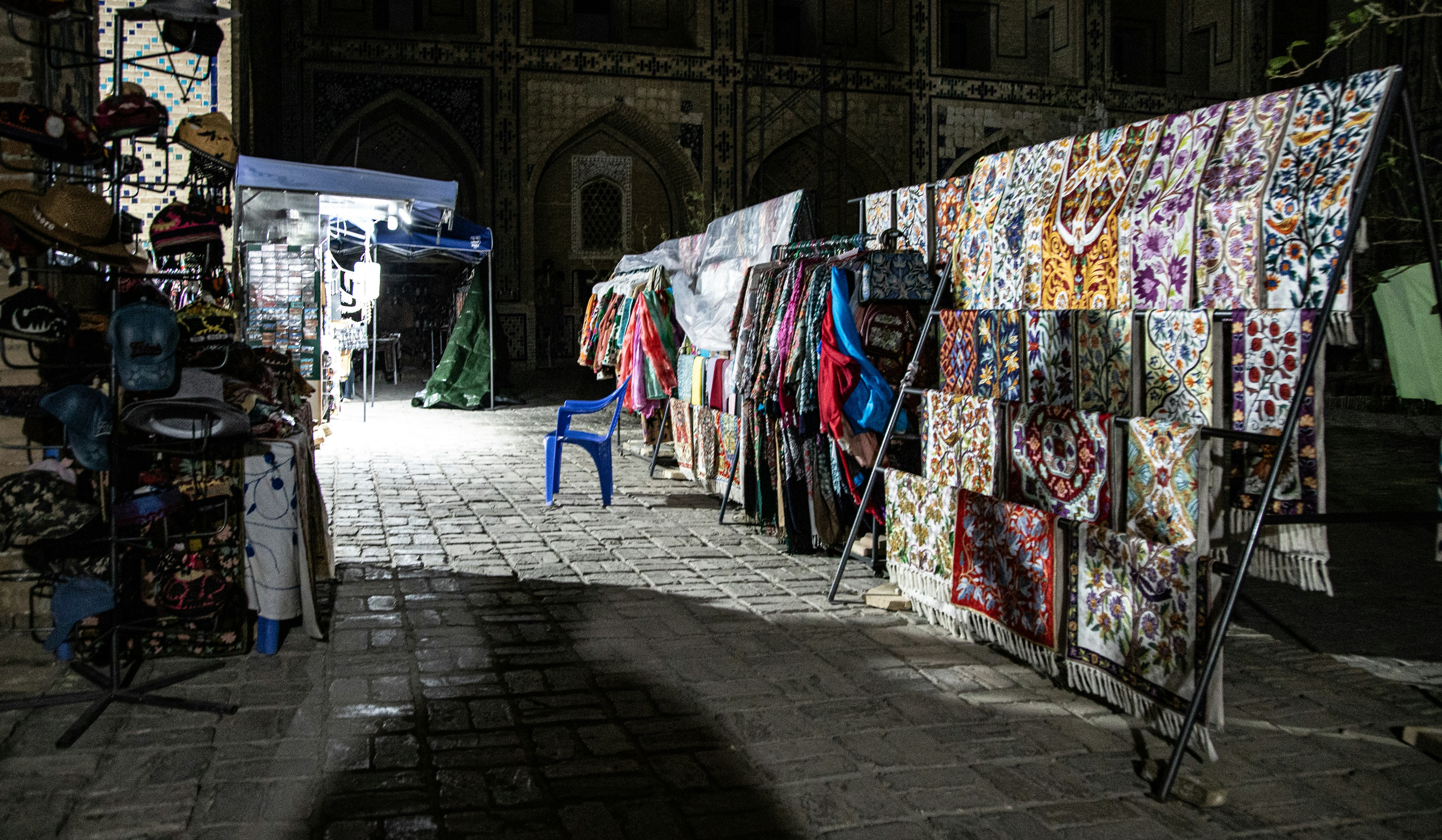 Market Arcades: Cloth Drapes and Stacked Hats in Dim Light