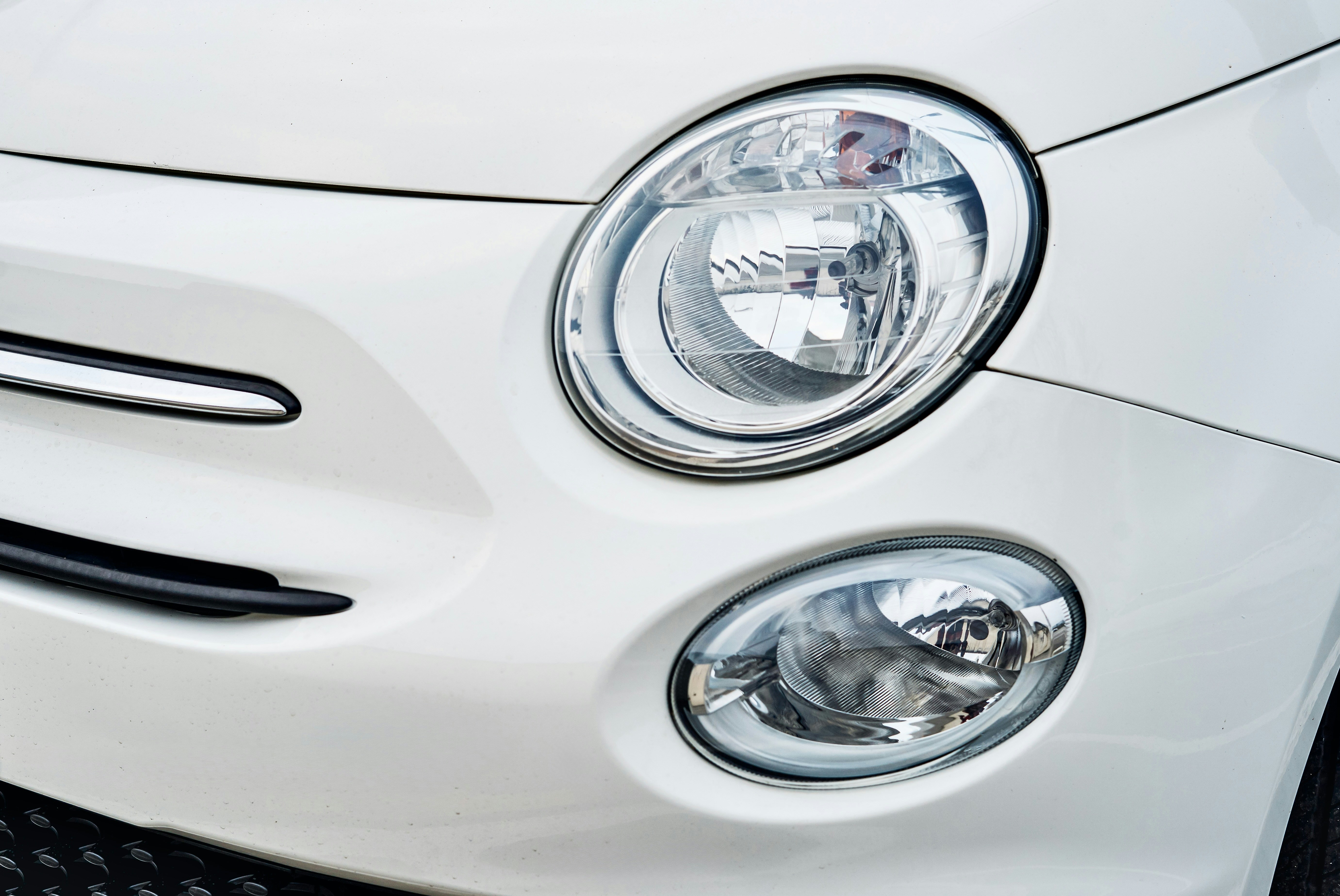 Close-Up of a White Fiat–Style Front End with Dual Circular Headlights