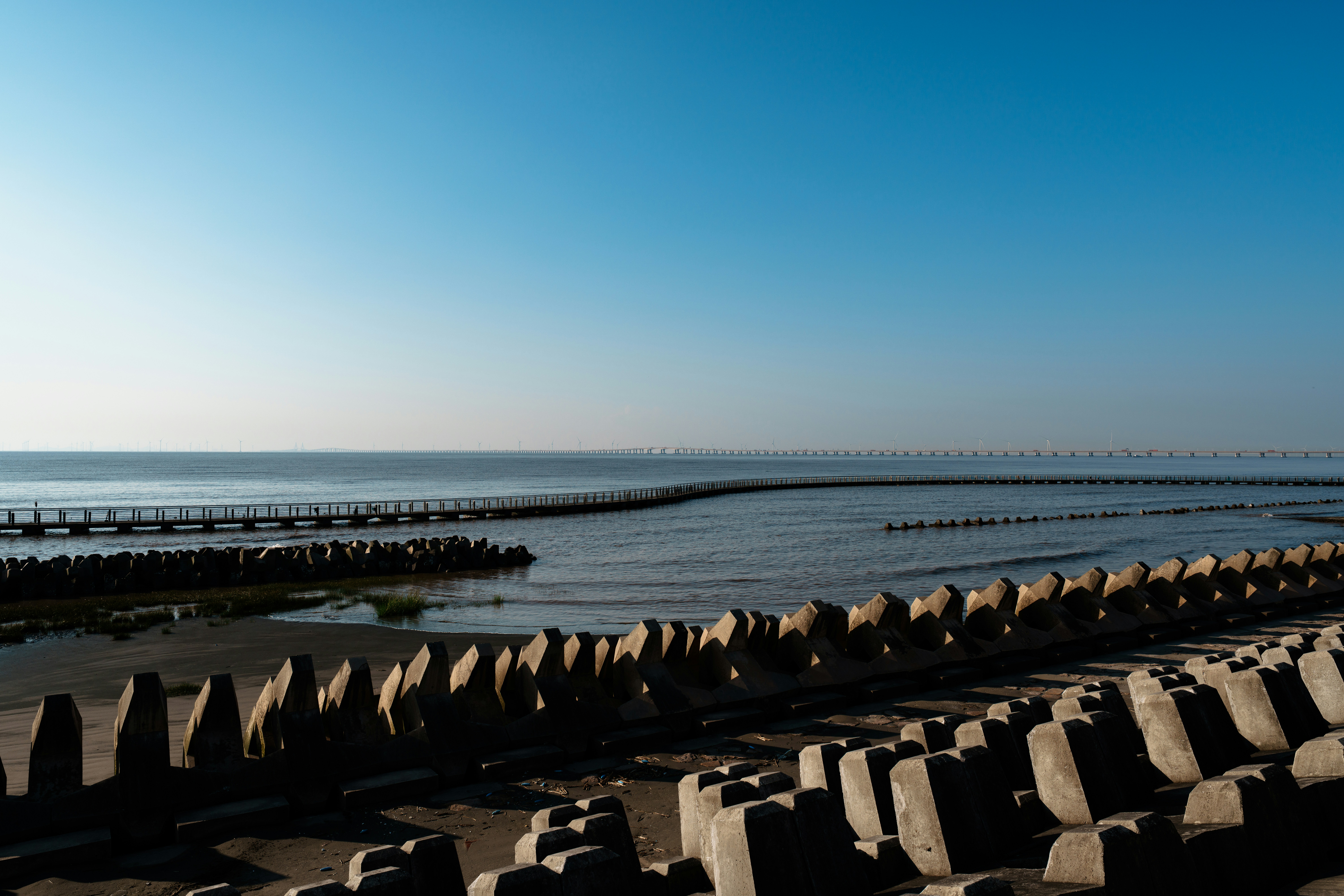 Concrete Breakwaters Meeting the Sea: A Quiet Shoreline Under a Clear Sky