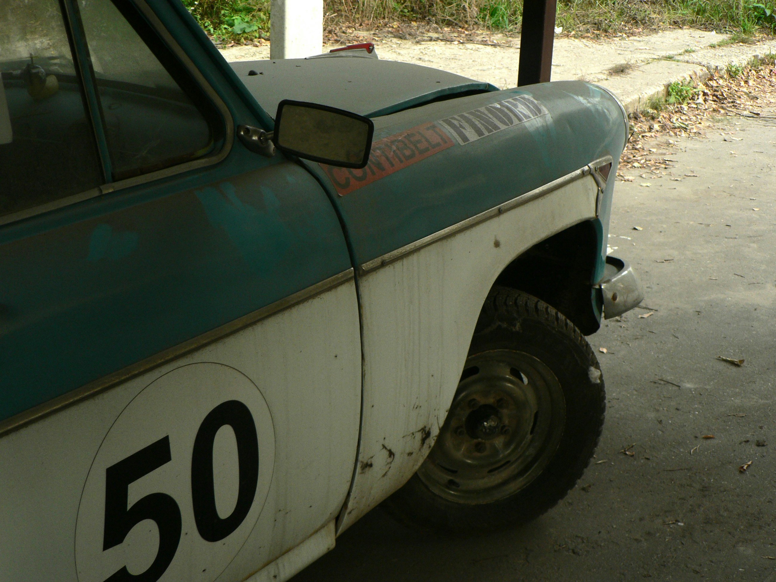 Weathered Classic: A Vintage Pickup Resting Under Sparse Shade