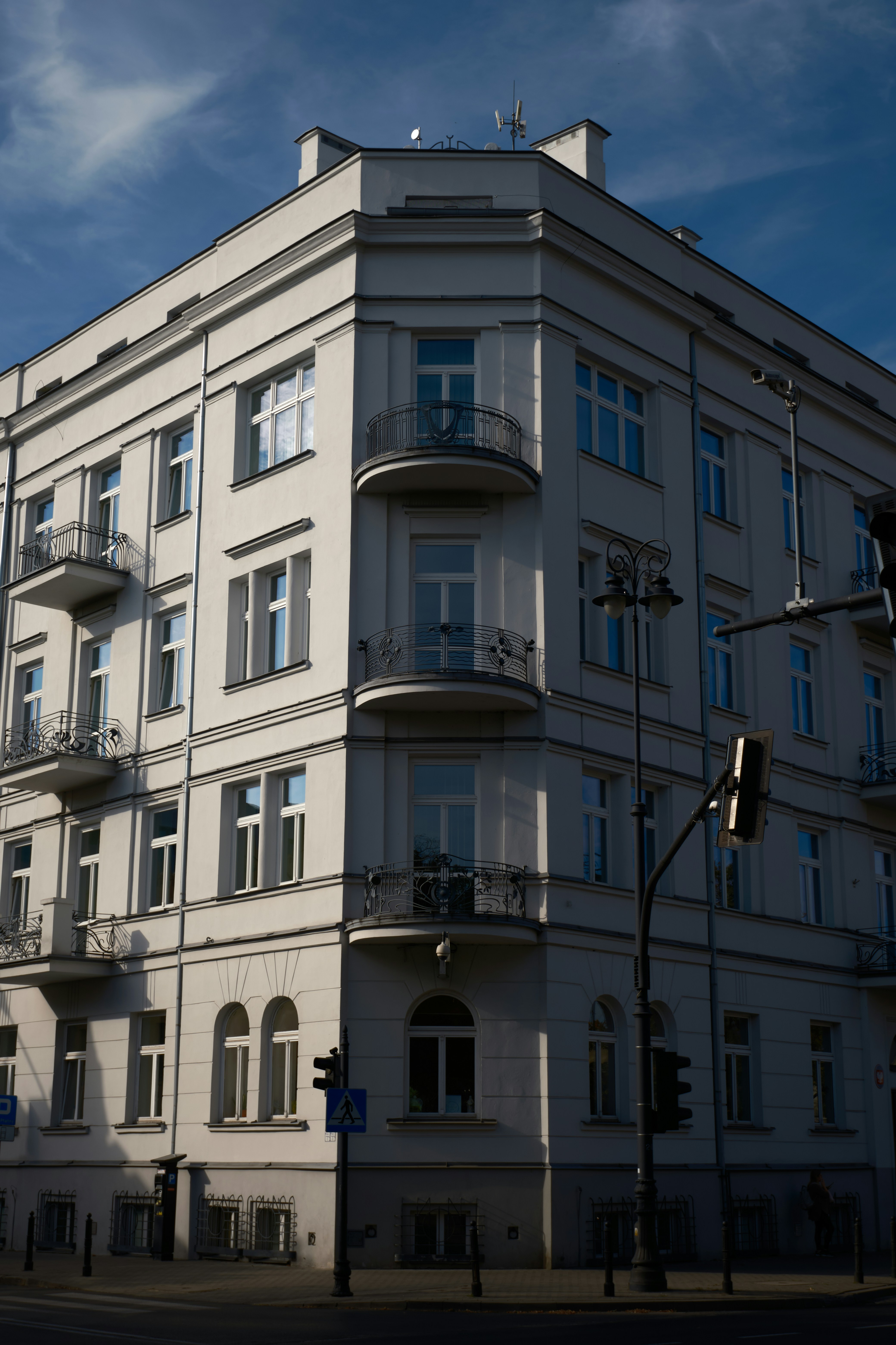 Cornered Grandeur: A Sunlit European Facade with Curved Balconies