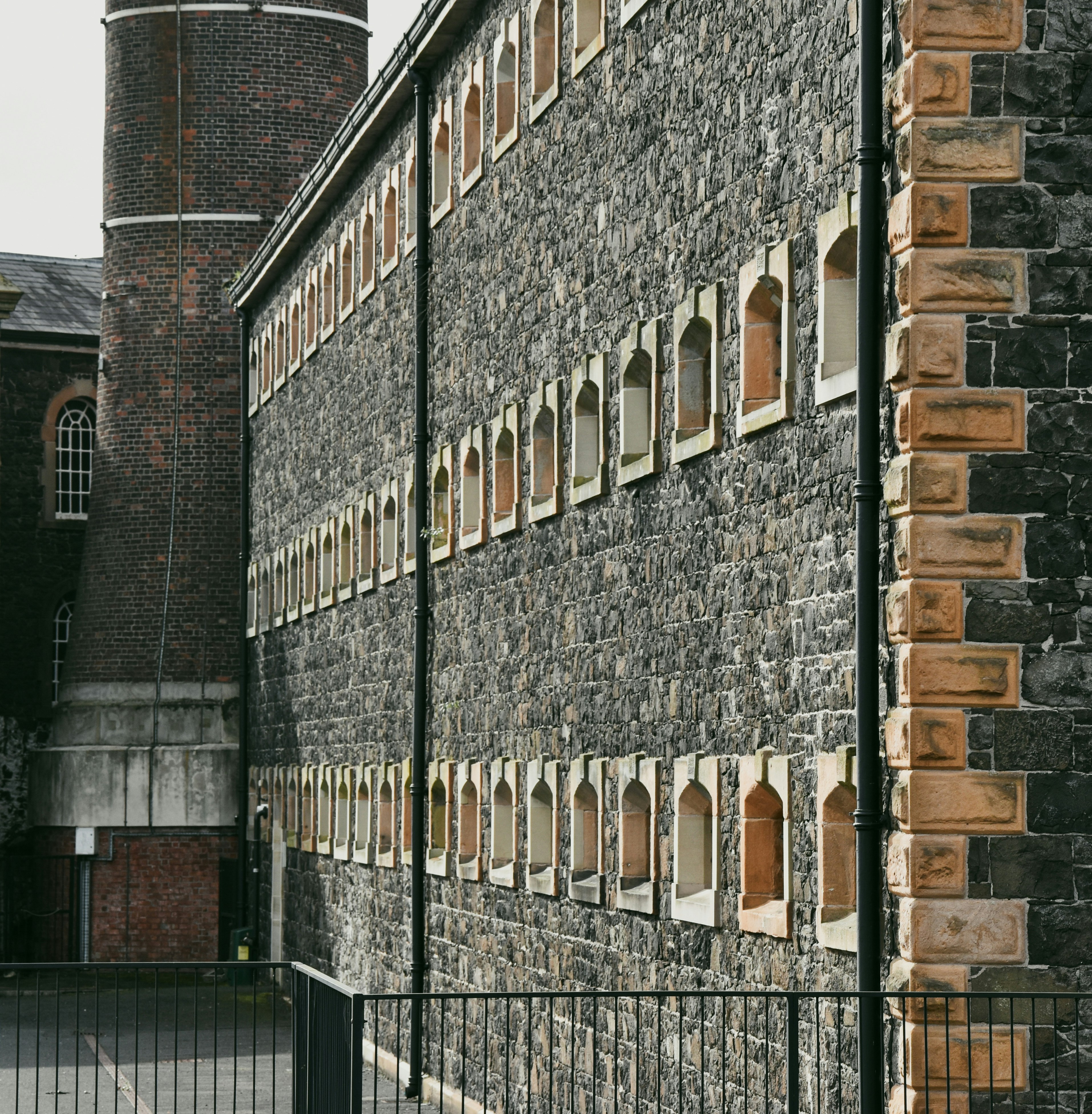 Brick-and-windowed Corridor: A Repetition of Arches Along the Towered Wall