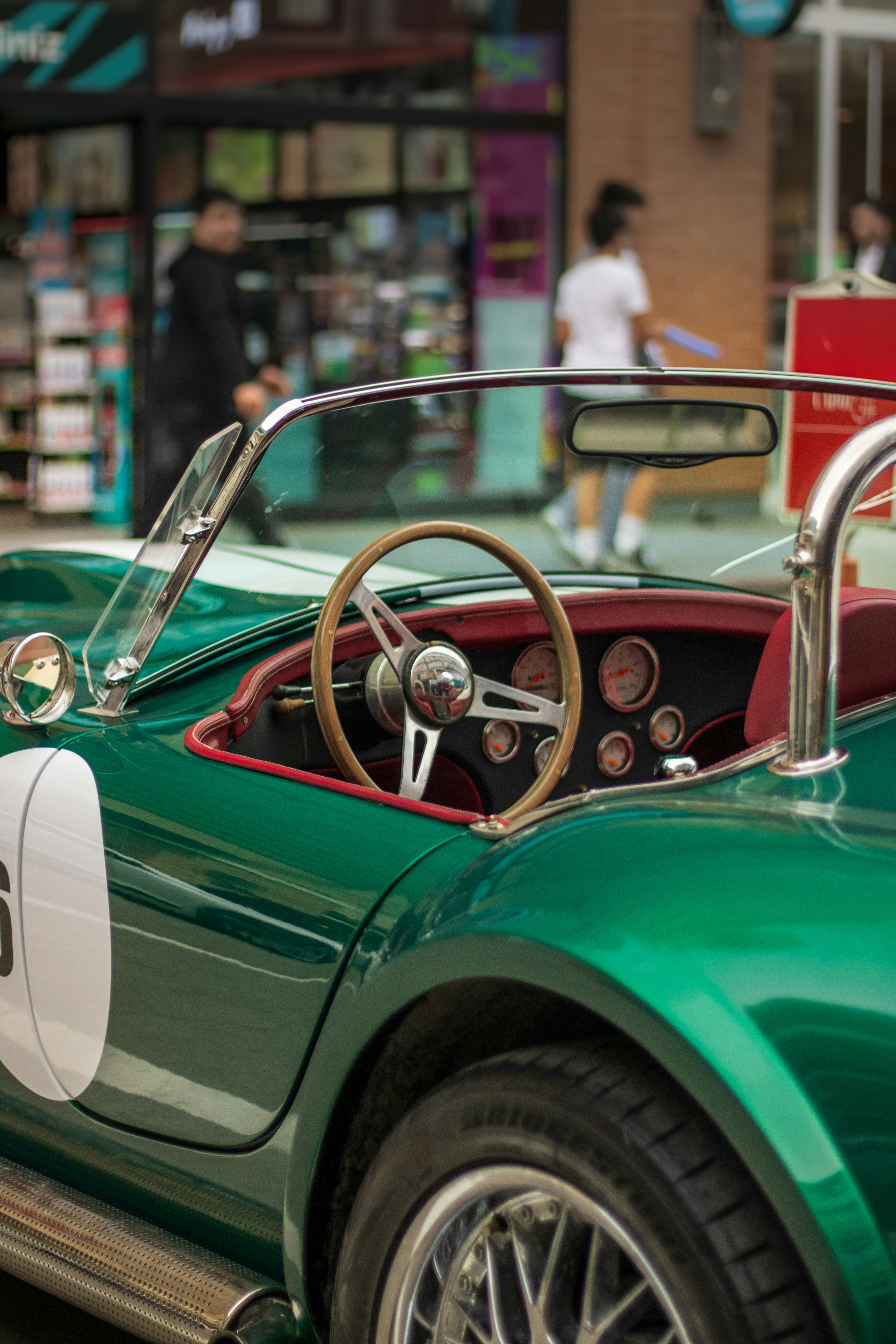 Green Classic: A Convertible’s Chrome Smile in the City Fray
