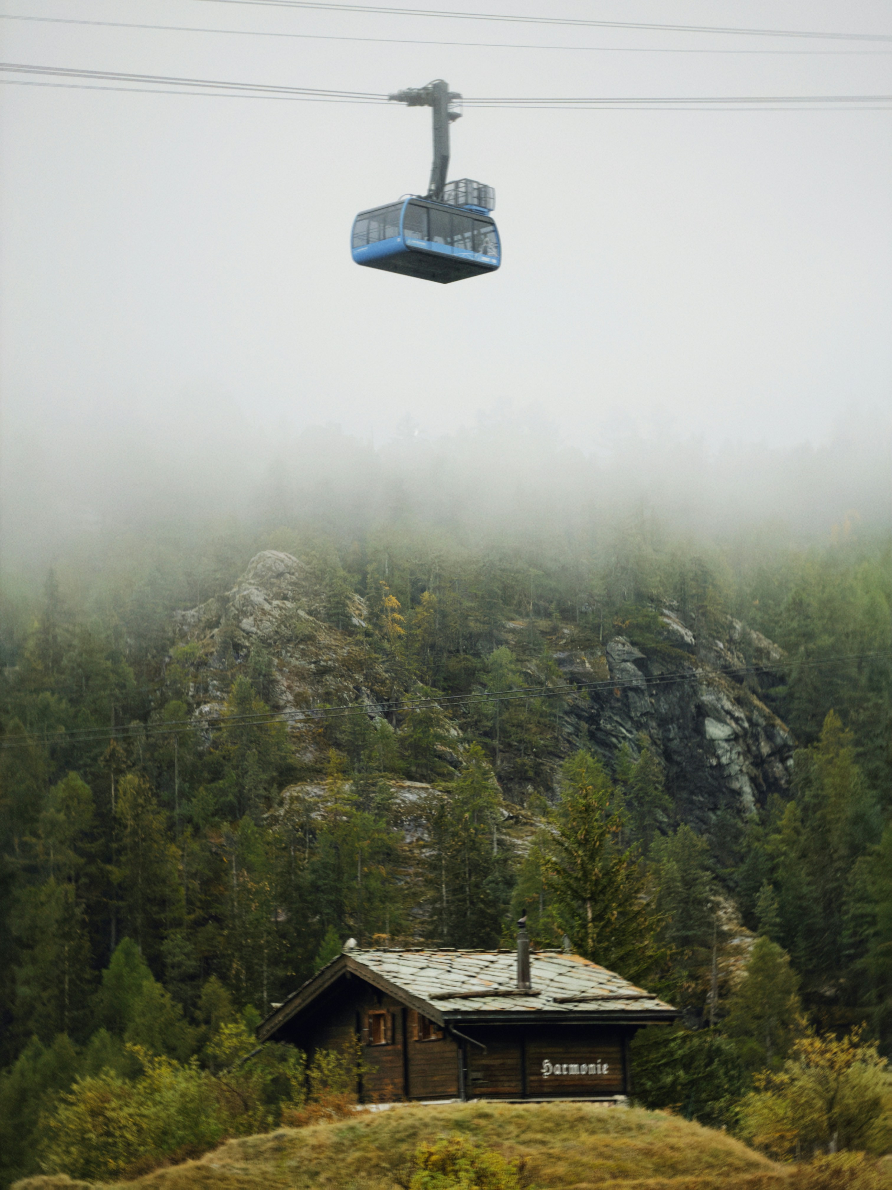 Cable Car Above a Misty Alpine Cabin