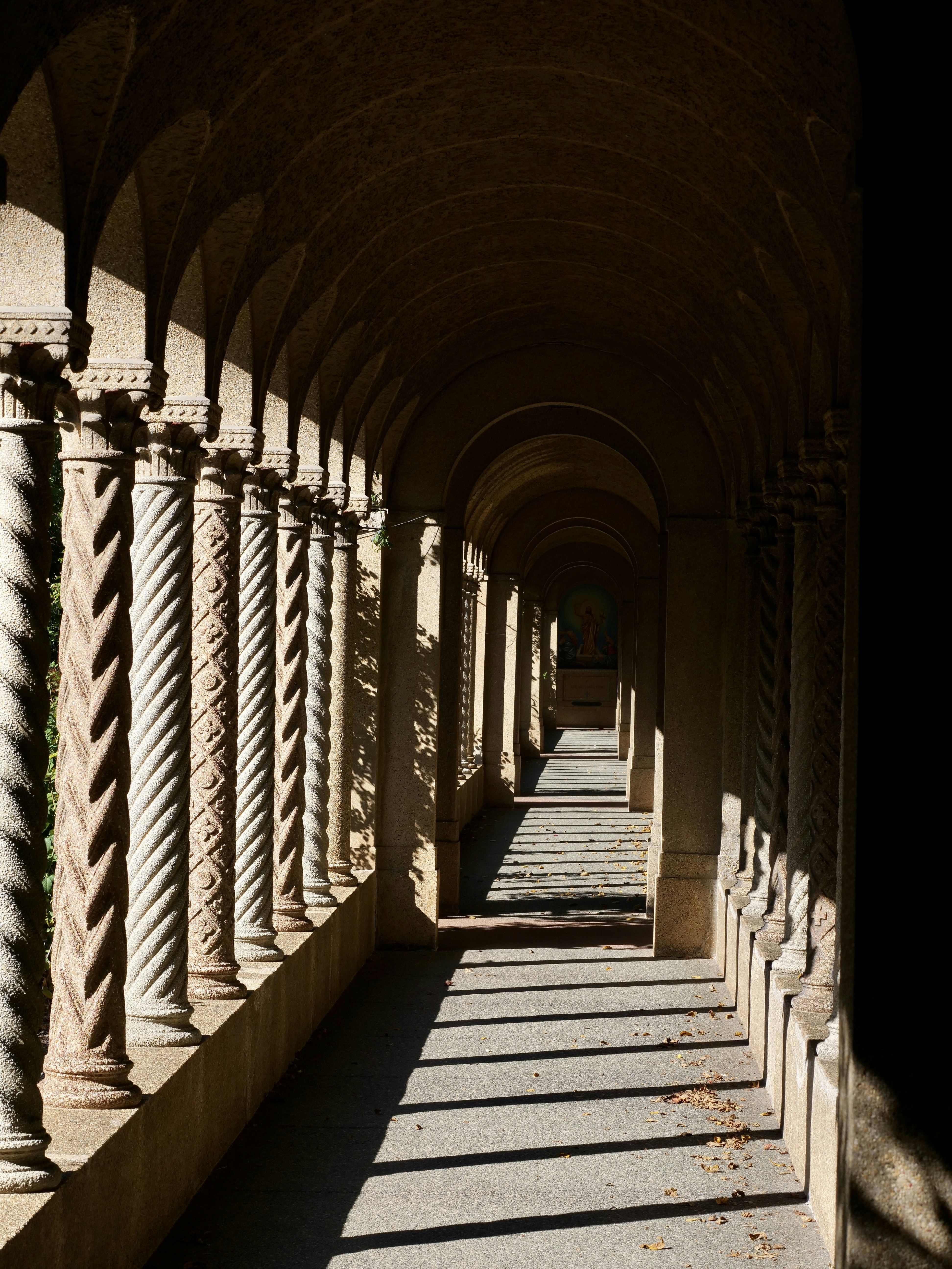 Sunlit Cloister: Shadows and Spiral Columns in a Deserted Arcade