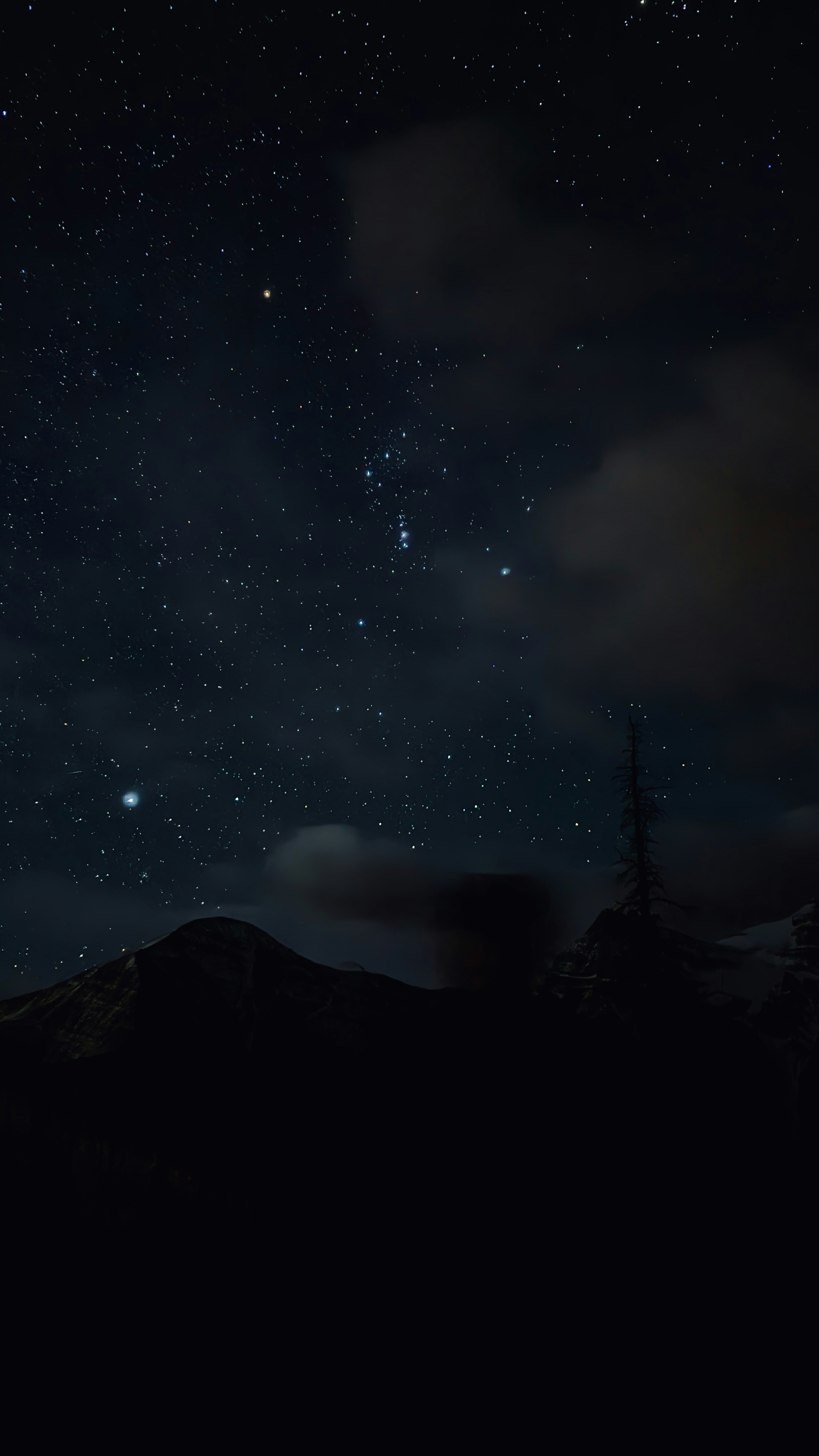 A starry night sky with the constellation Orion above dark mountain silhouettes