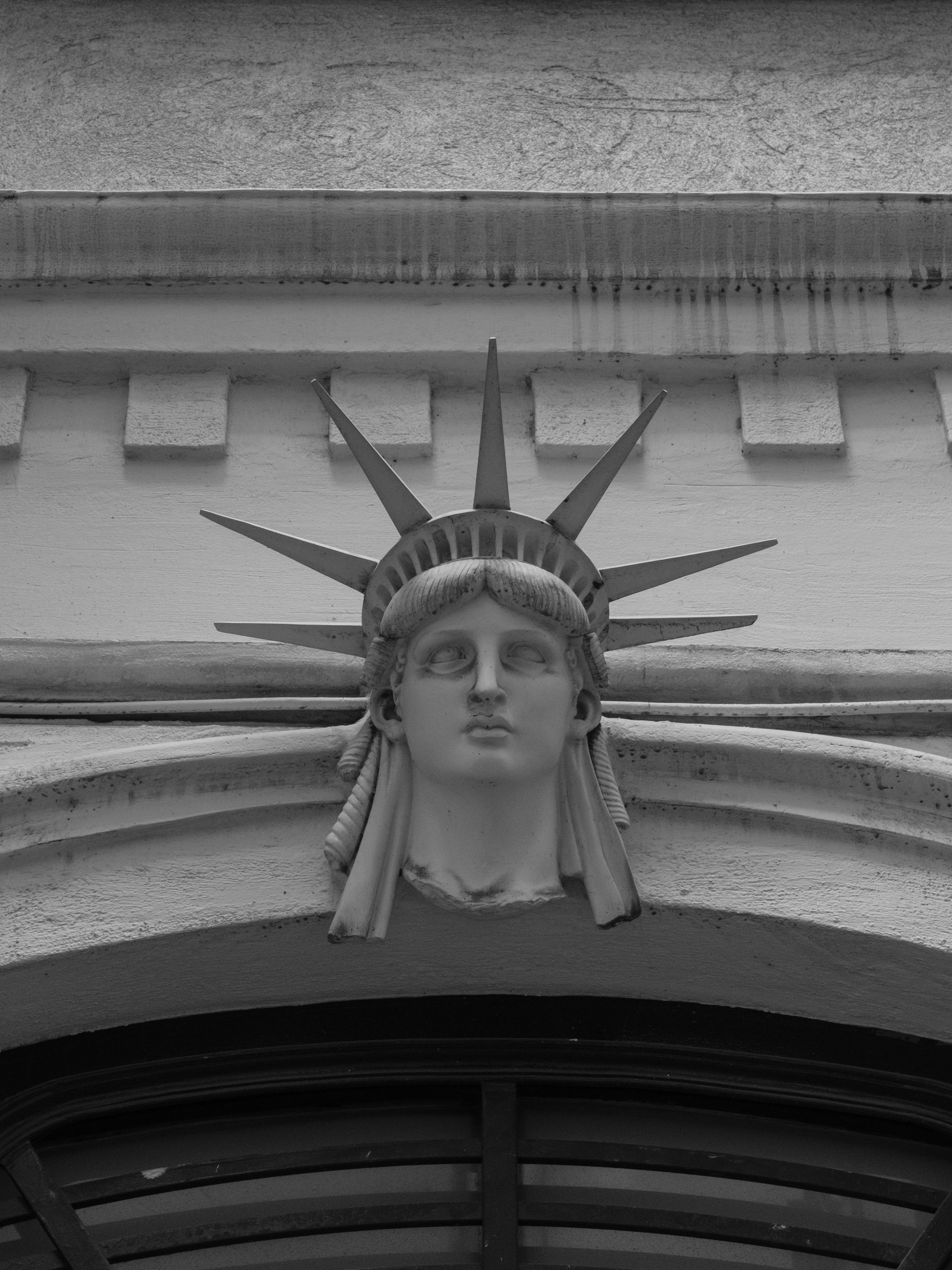 Stone Sentinel: The Crowned Gaze Above the Arch