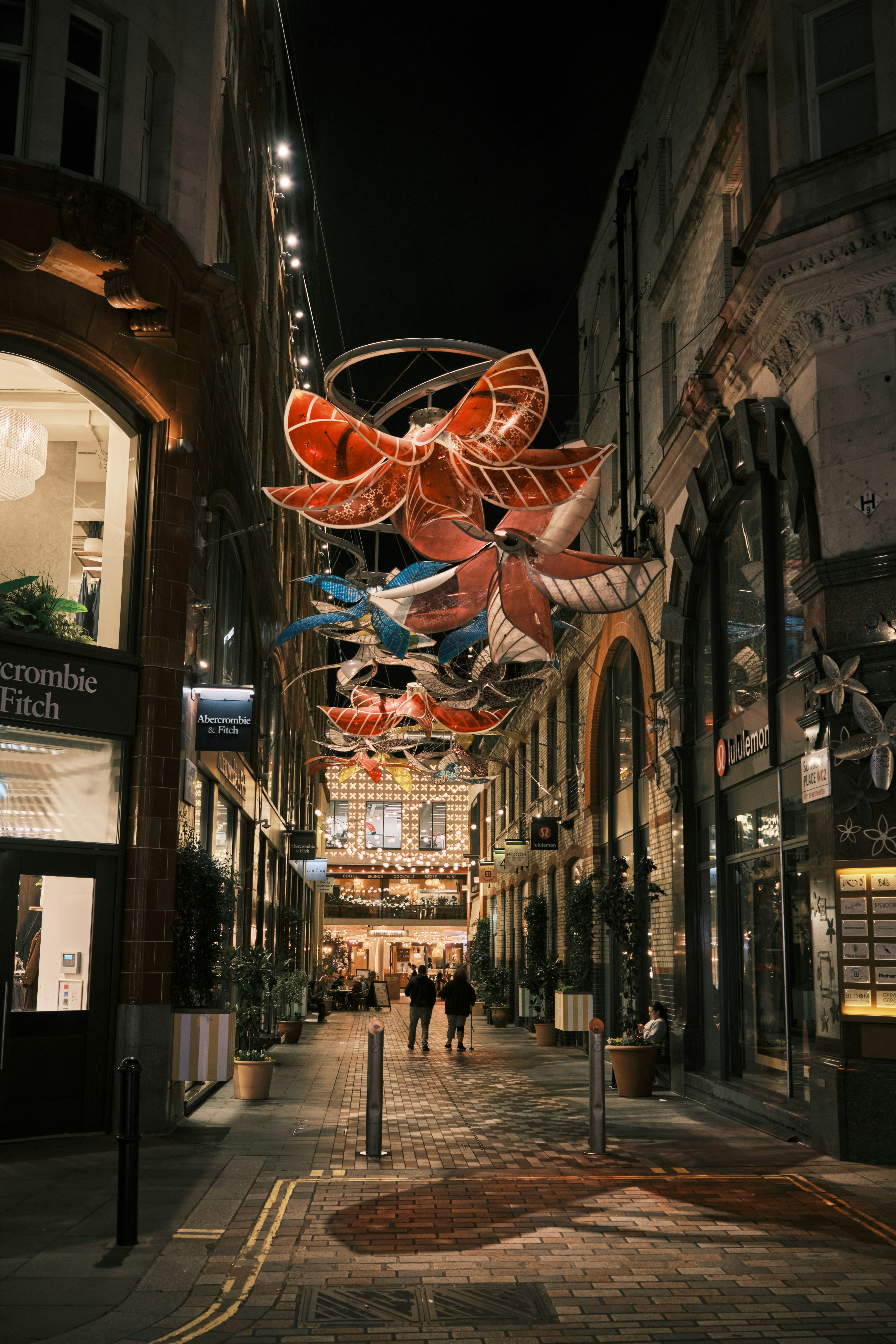 Night-lit Arcades: Floating Lantern Flowers Over a Quiet Street