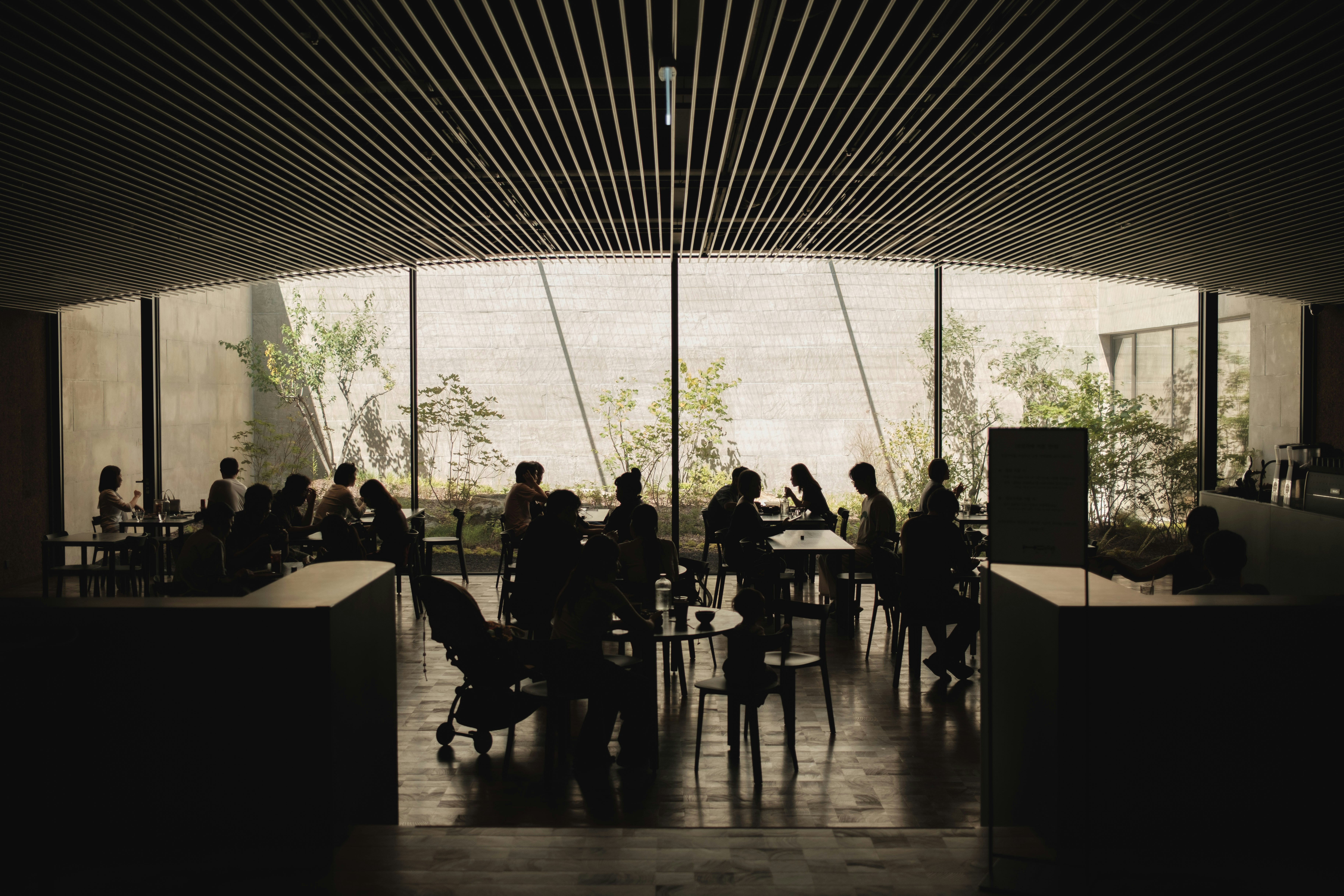 Quiet Conversation in a Sunlit Café Corridor