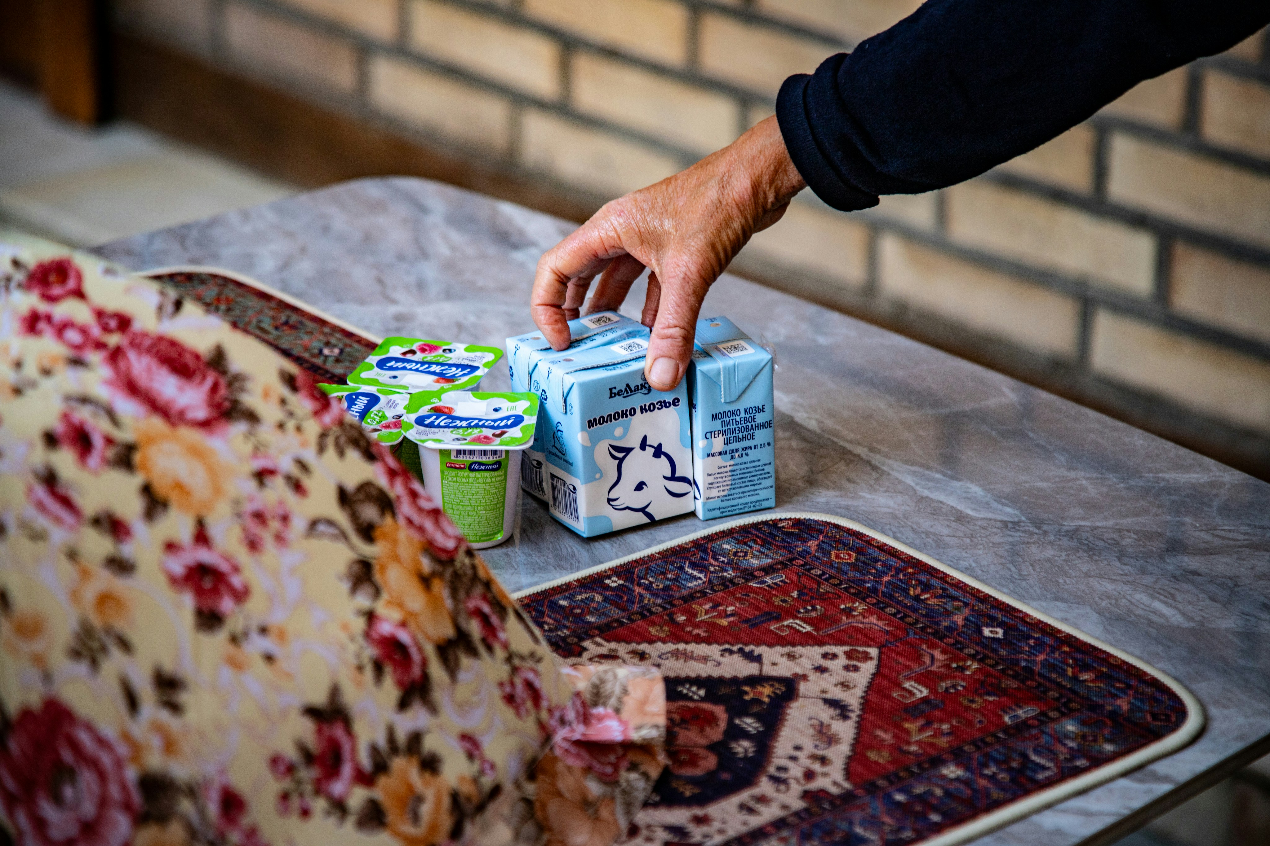 A Quiet Ritual at the Table: Milk Cartons Tucked by a Hand