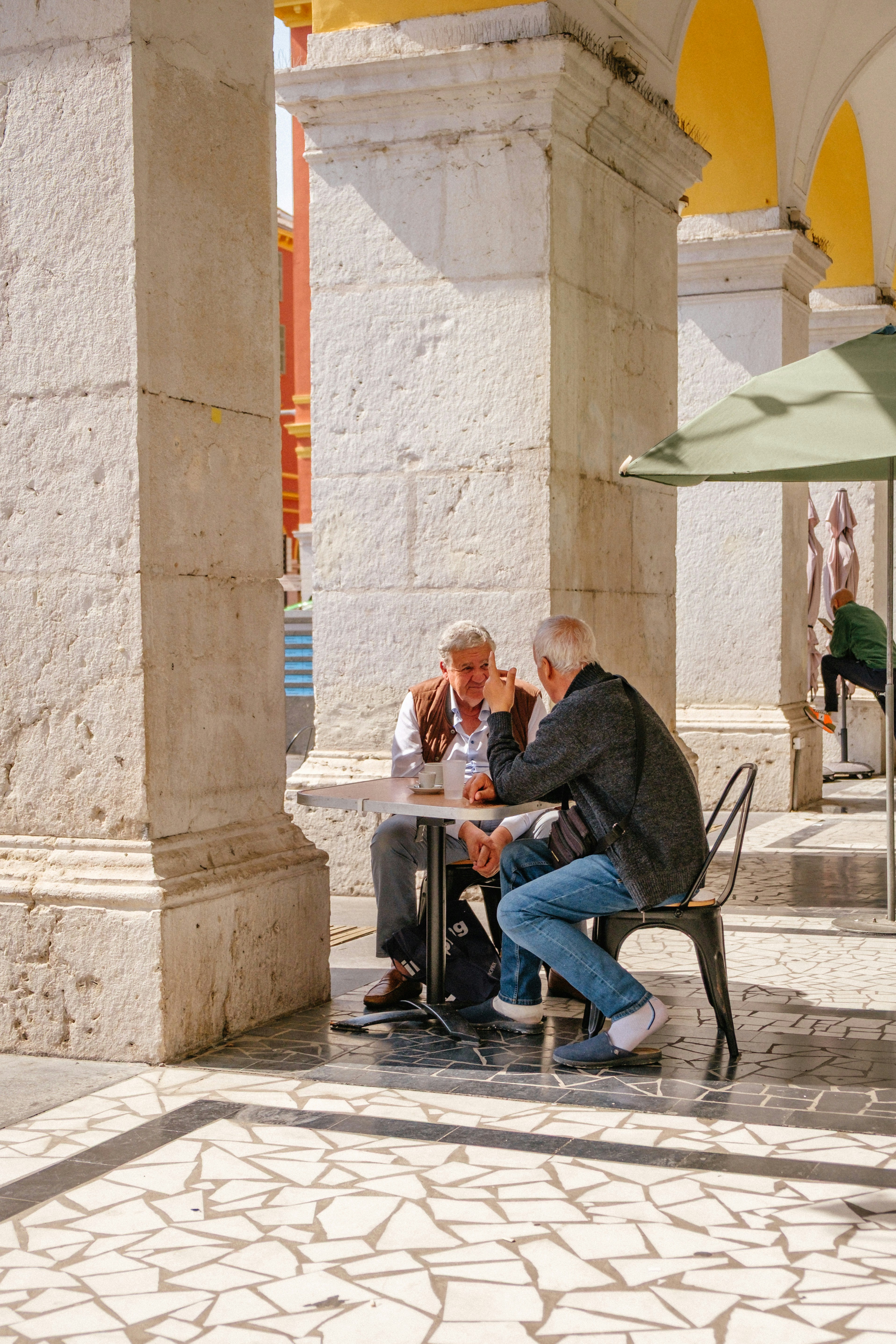 Shared Moment at a Sunlit Courtyard Table