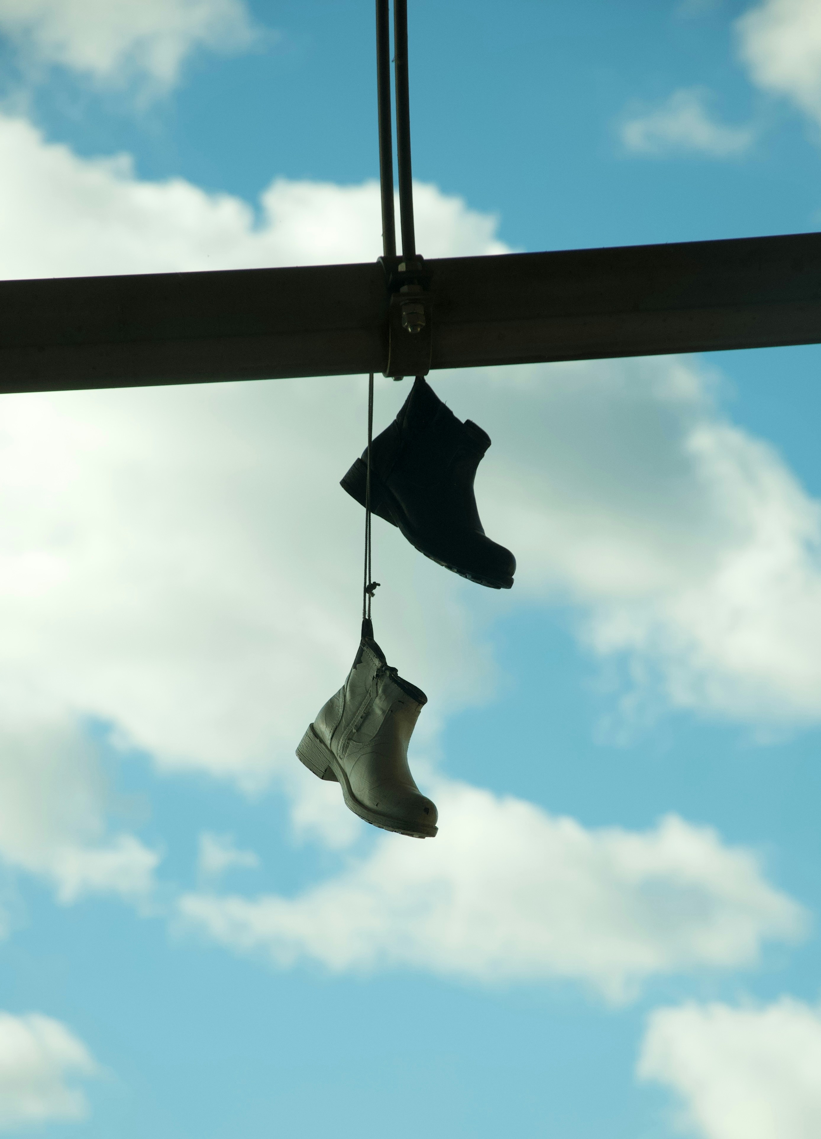Shoes on a Wire: A Minimal Shrine to Flight Against a Bright Sky