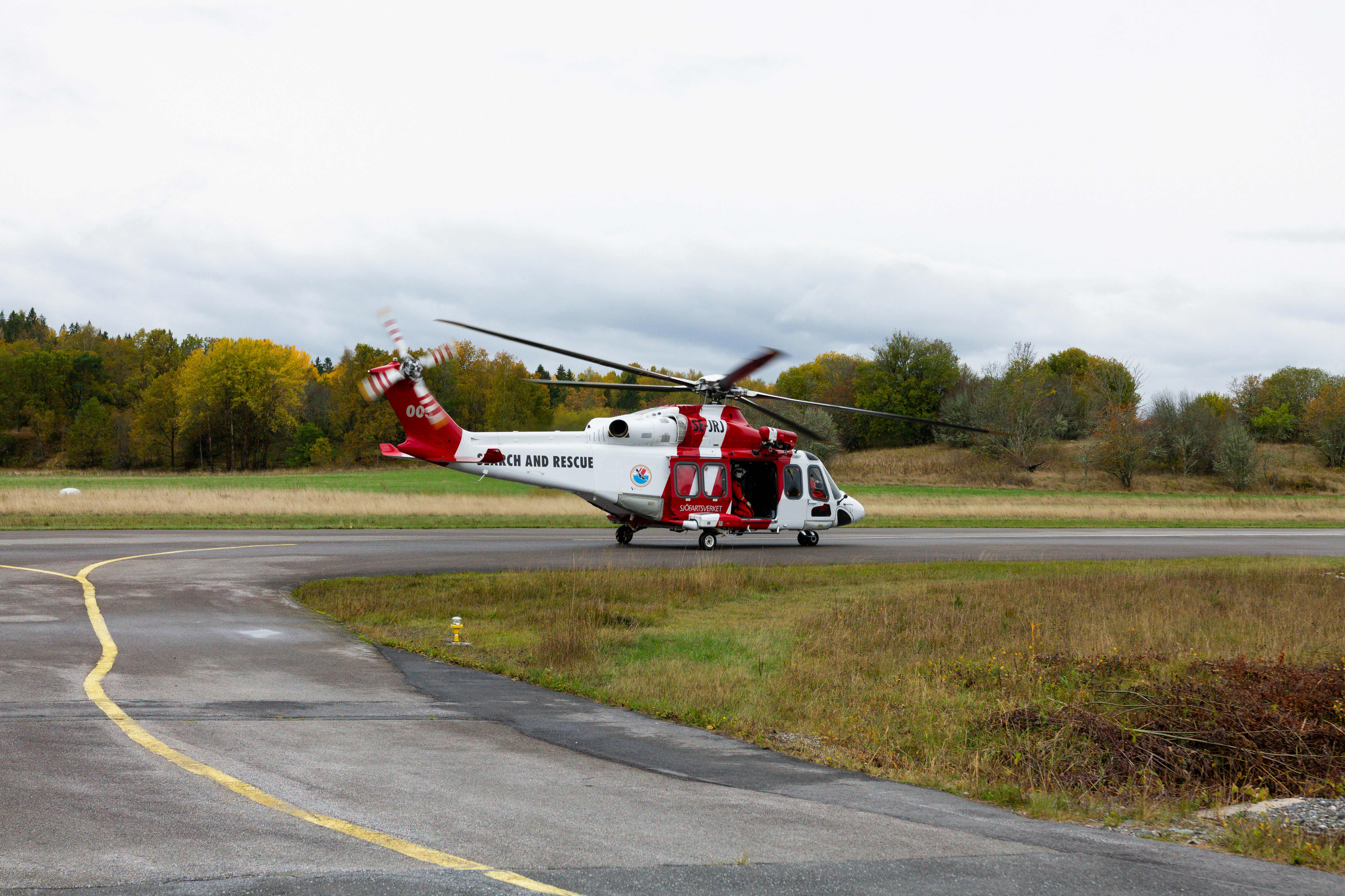 Rescue Helix: A red-and-white EMS helicopter lands on a rural tarmac