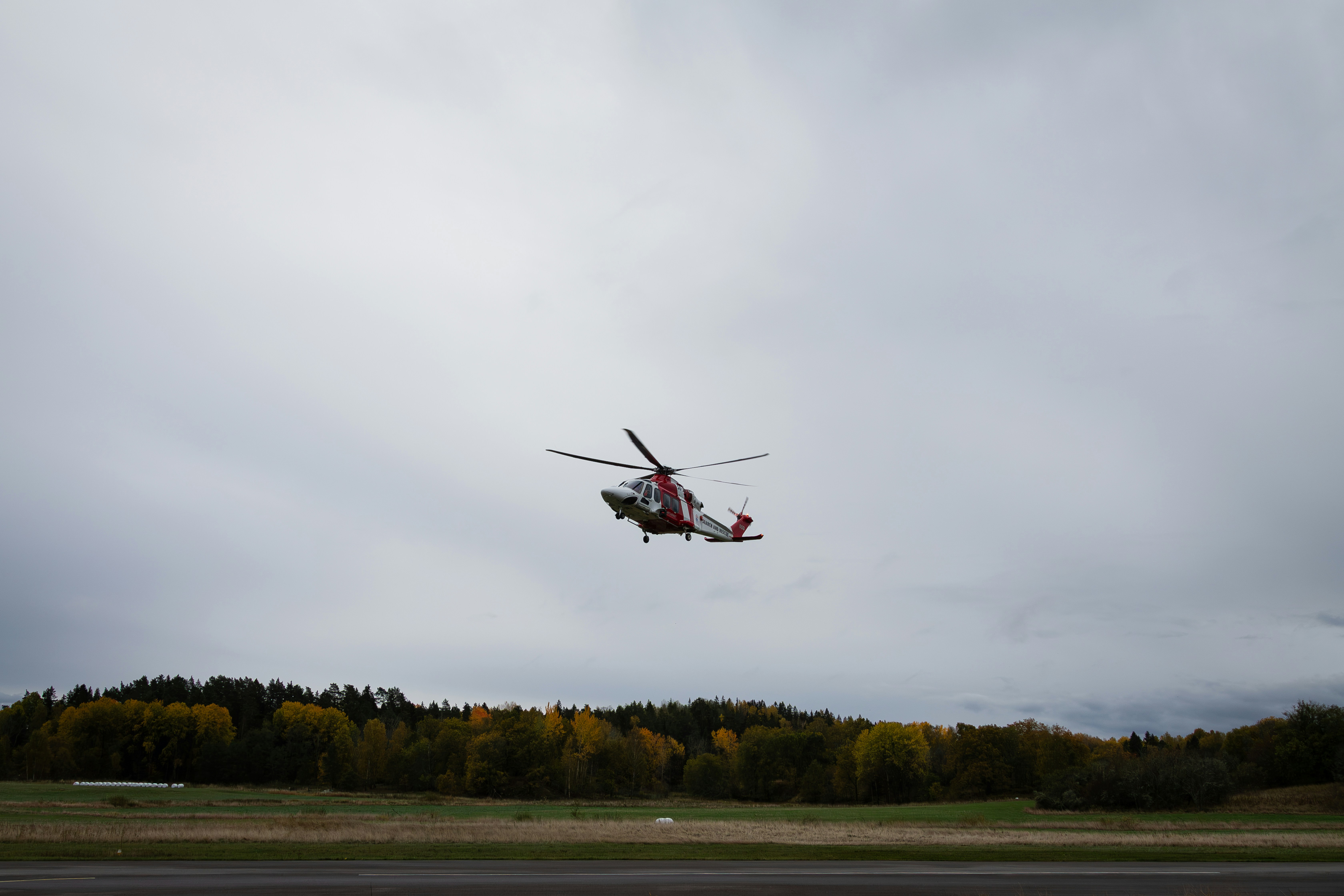 Helicopter Emerges Over Autumn Horizon