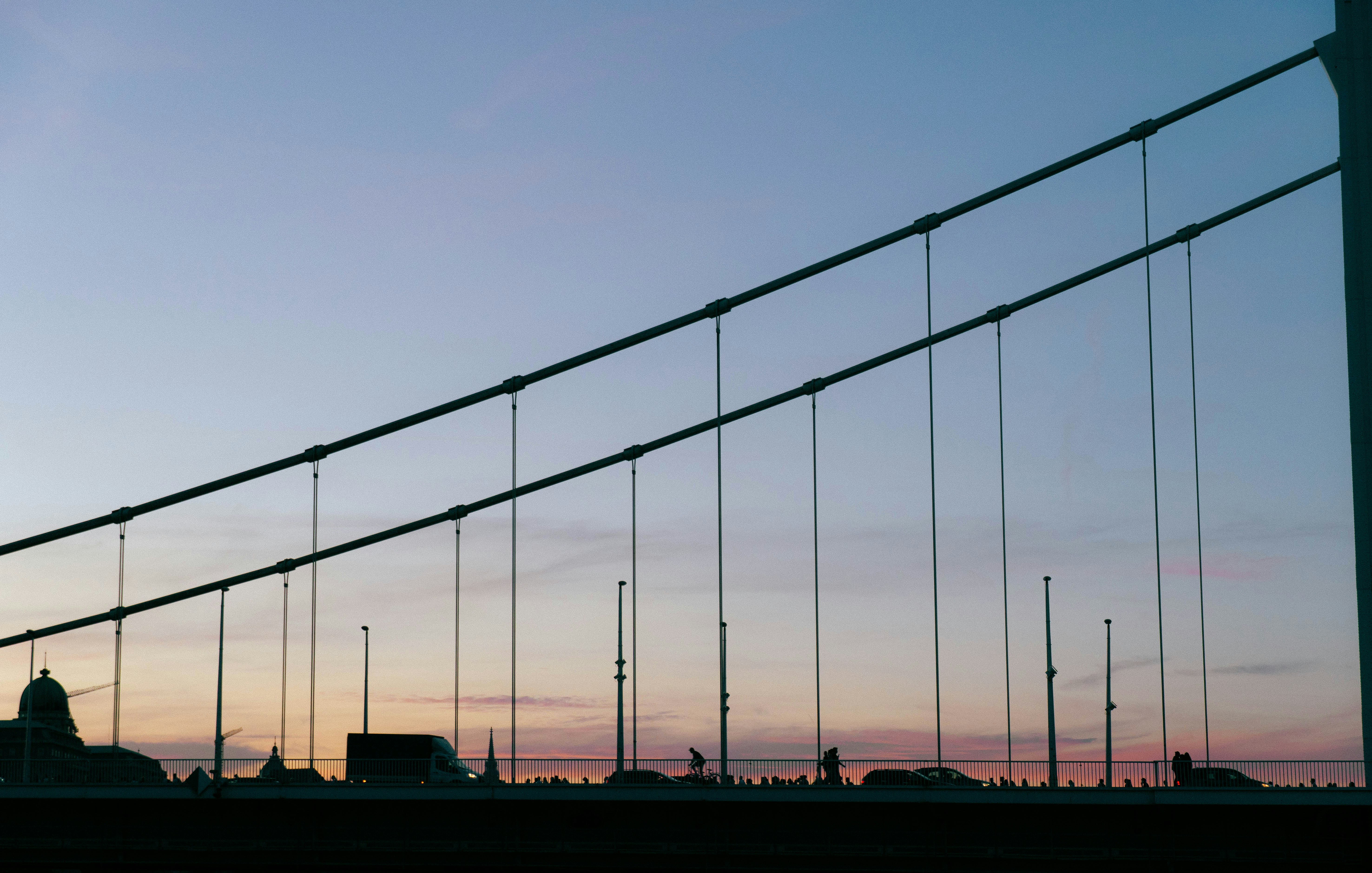 Silhouetted Suspension Cables at Dusk Over a Quiet Skyline