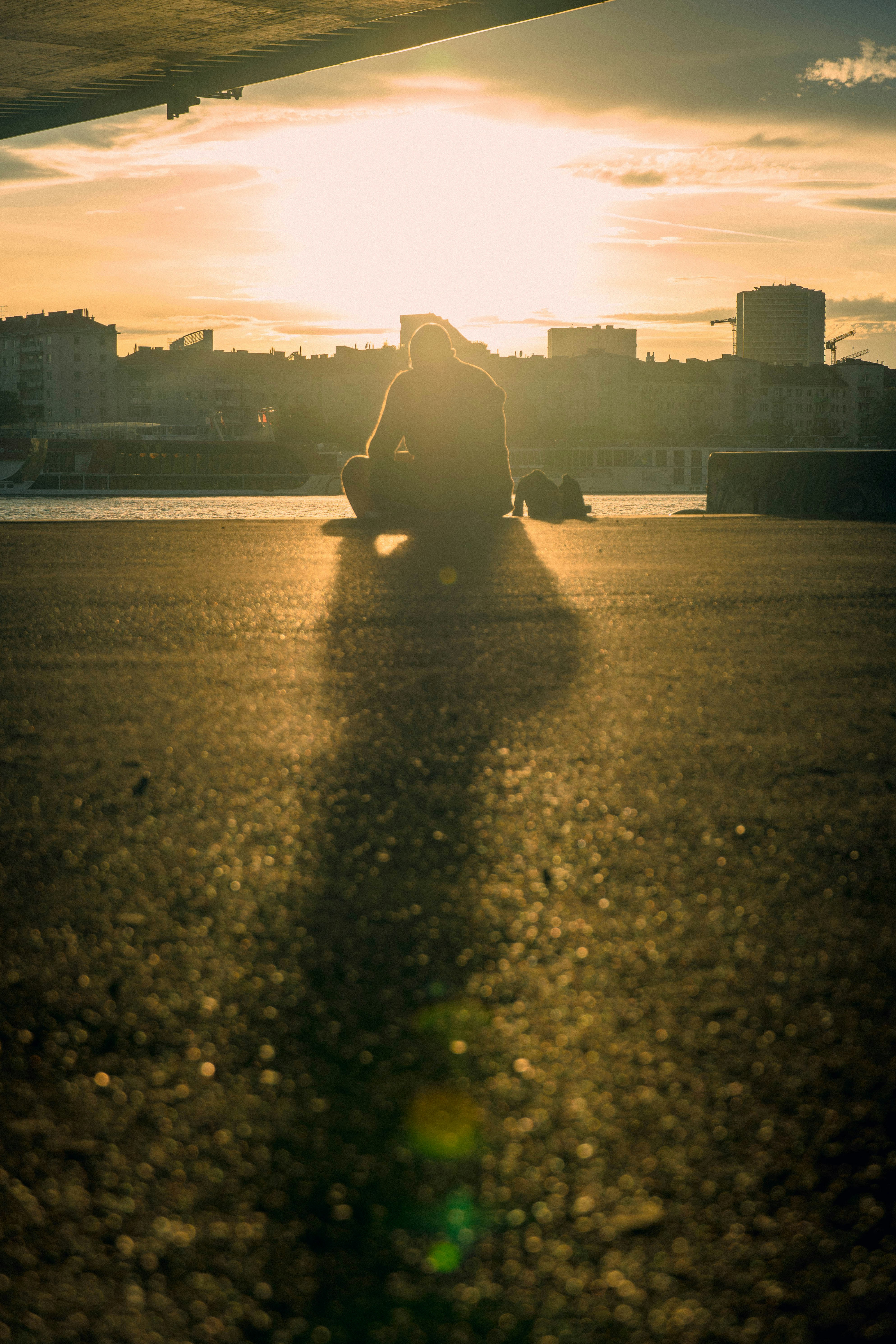 Sunlit Silhouette: A Quiet Moment by the Waterfront