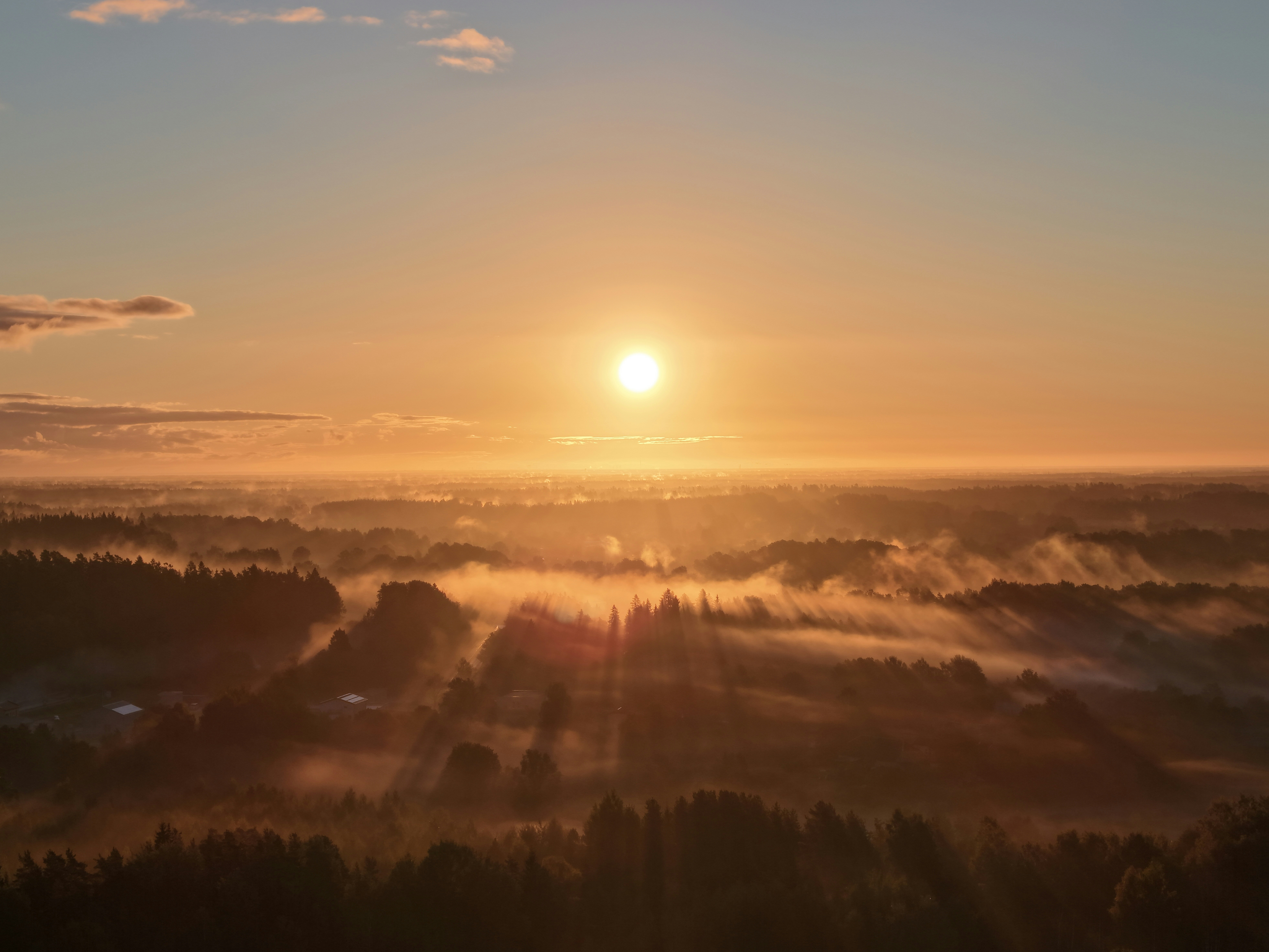 Sunrise Over Misty Fields: Aerial Dawn in Golden Haze