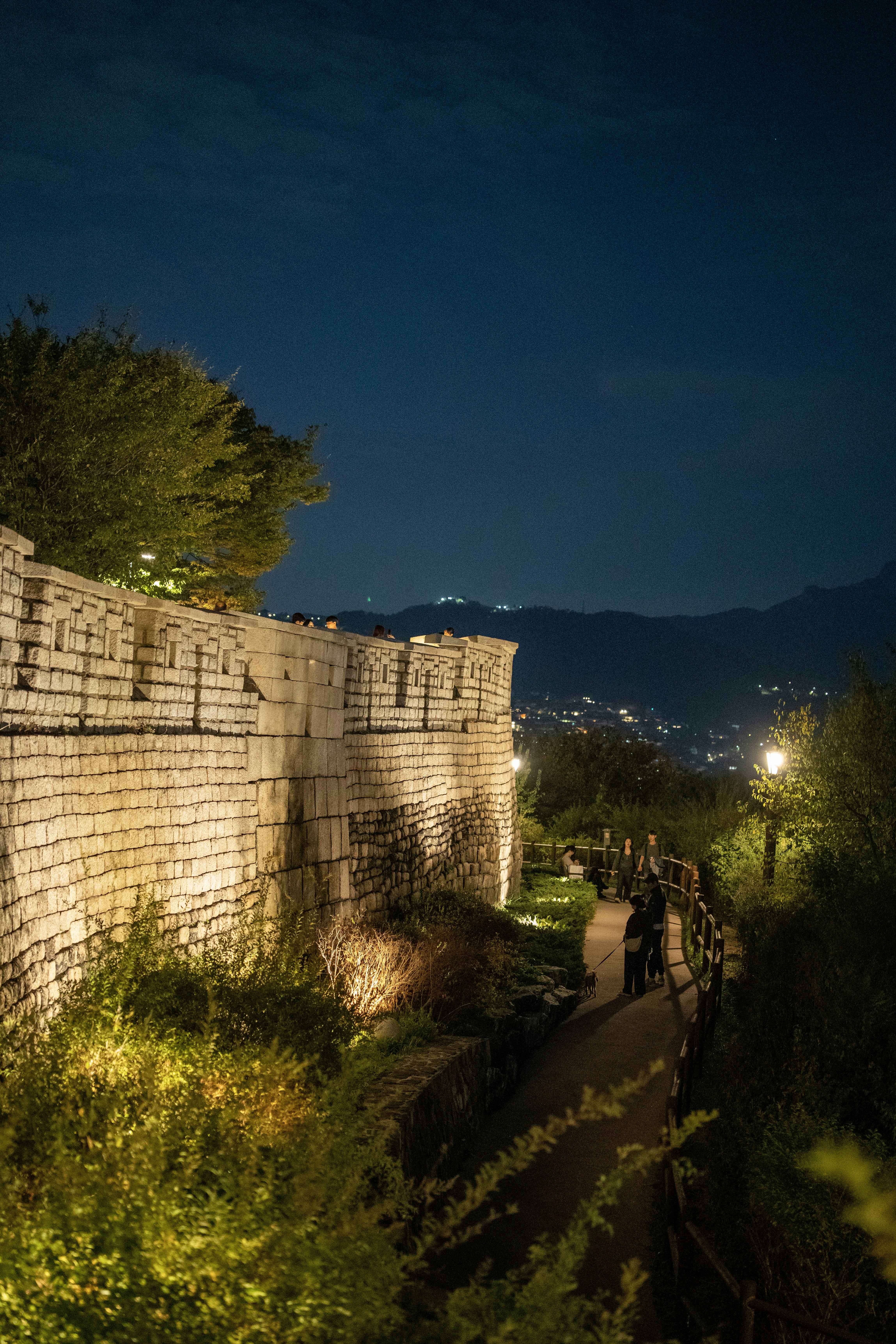 Moonlit walk along ancient stone ramparts under a quiet night sky