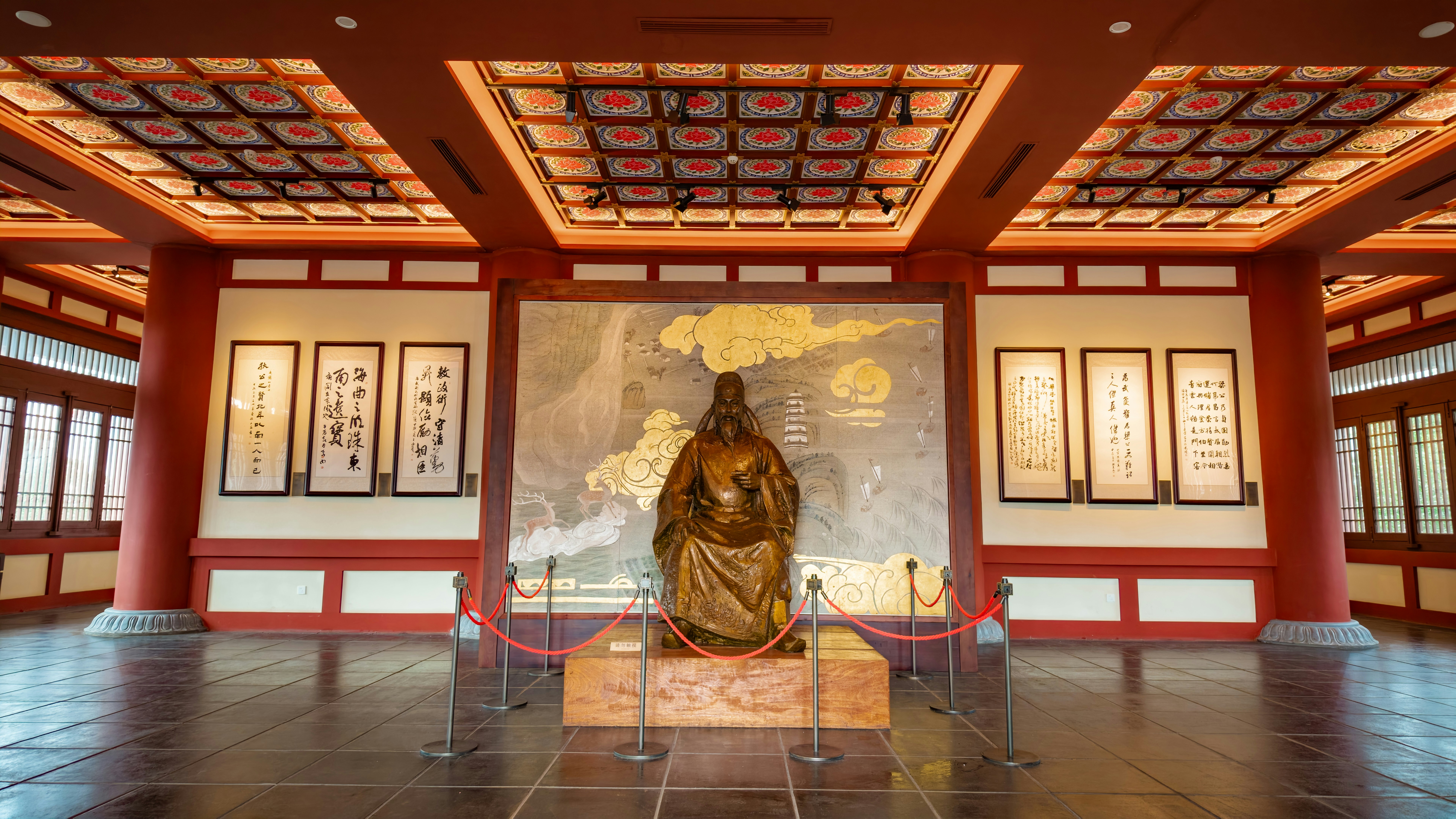 Centered Relief: A Solitary Statue Guarded by Velvet Ropes in a Traditional Hall