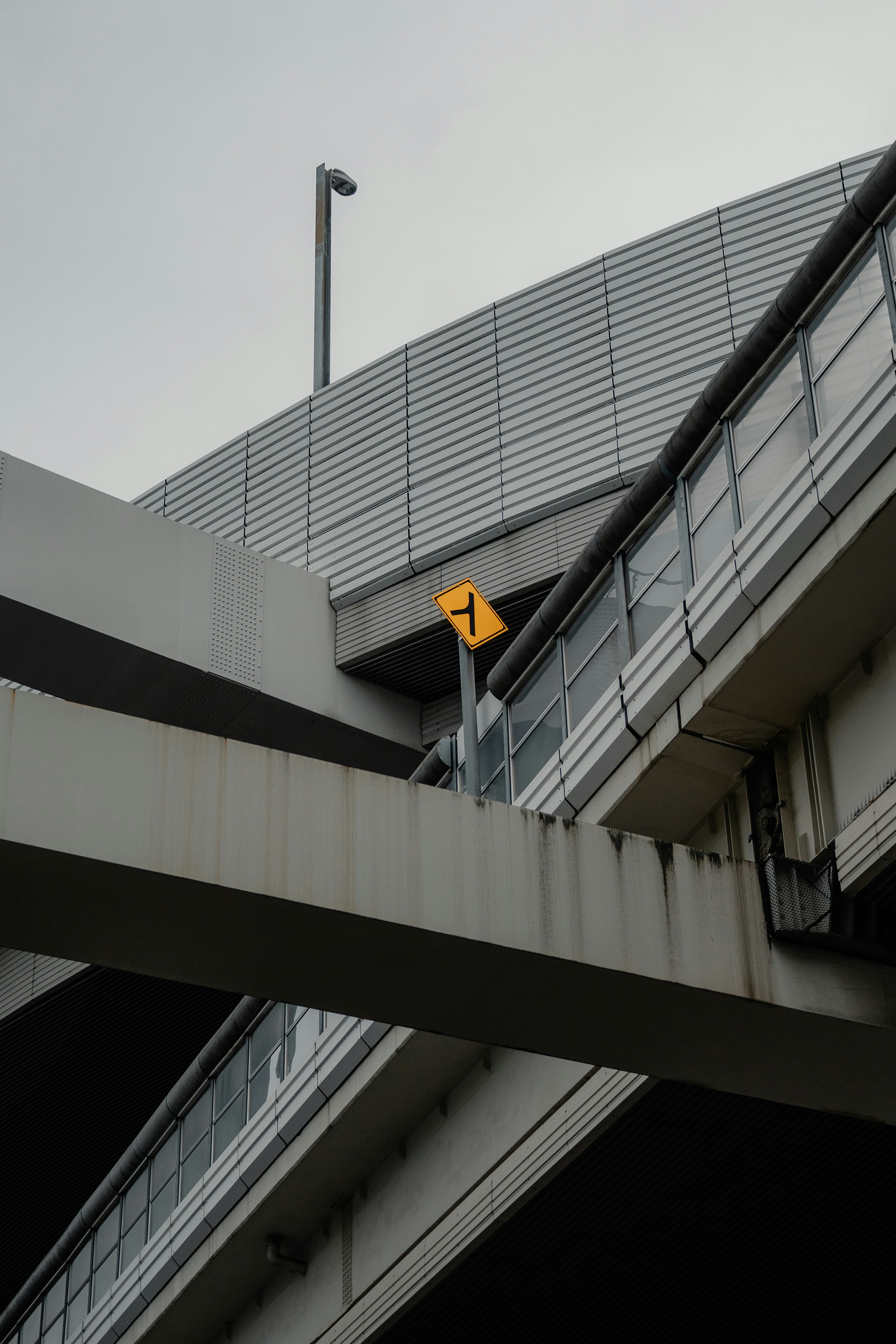 Urban Signal: A Yellow Arrow Watchs Over Concrete Arches