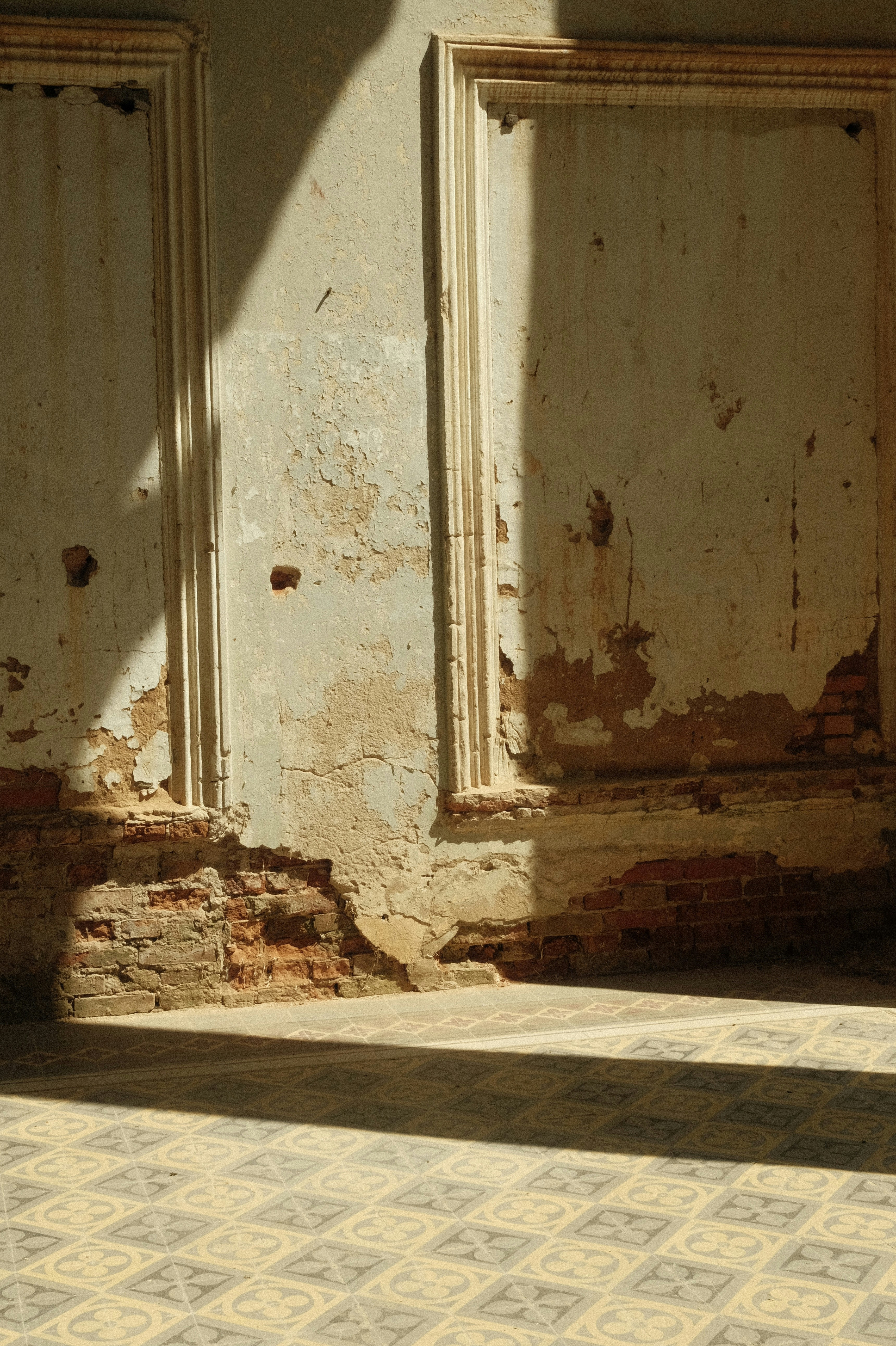 Sunlit Decay: A Wall in Quiet Shadow and Patterned Floor