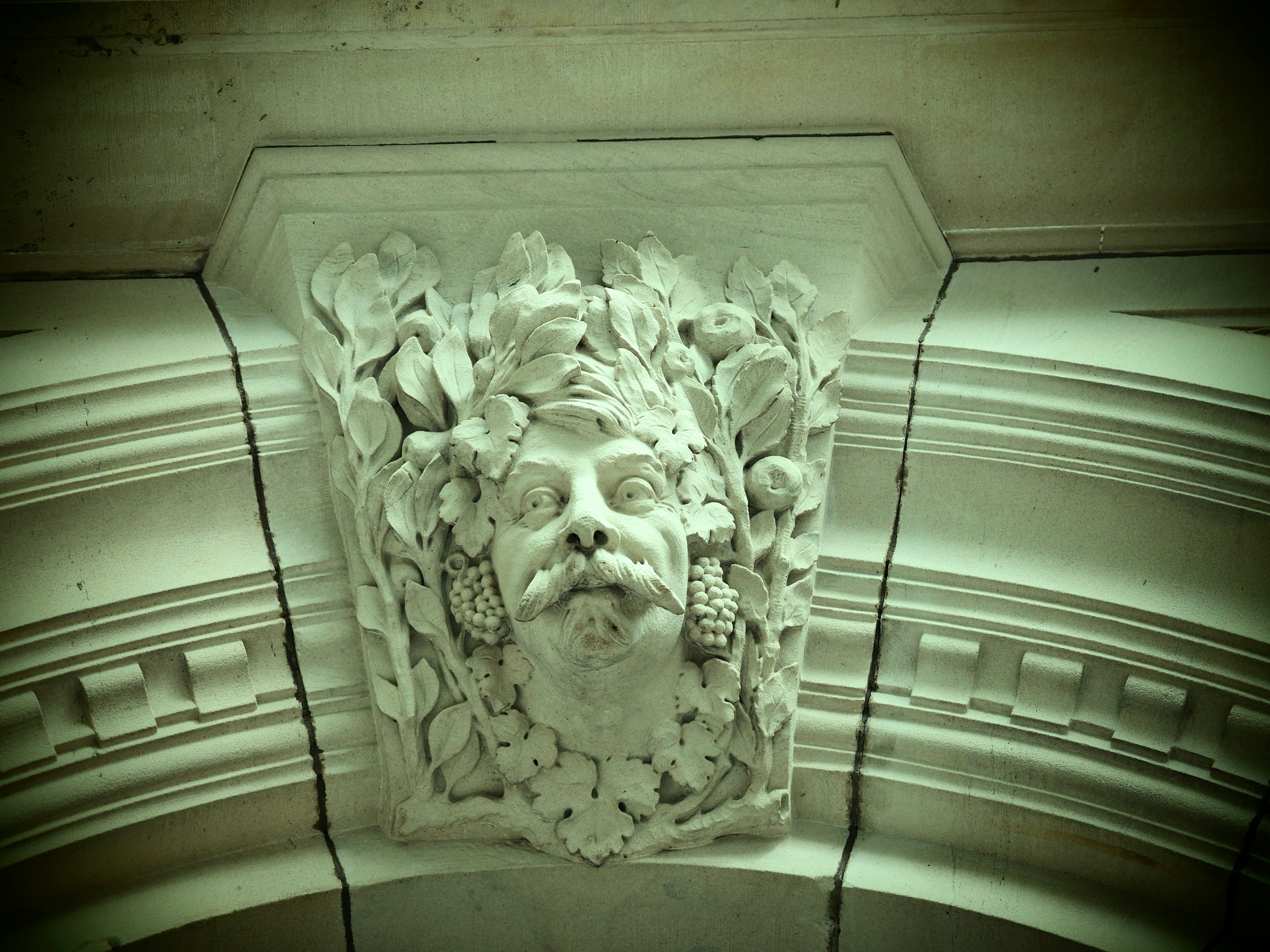 Carved Bust Beneath Stone Laurels: A Portrait in Stone Relief