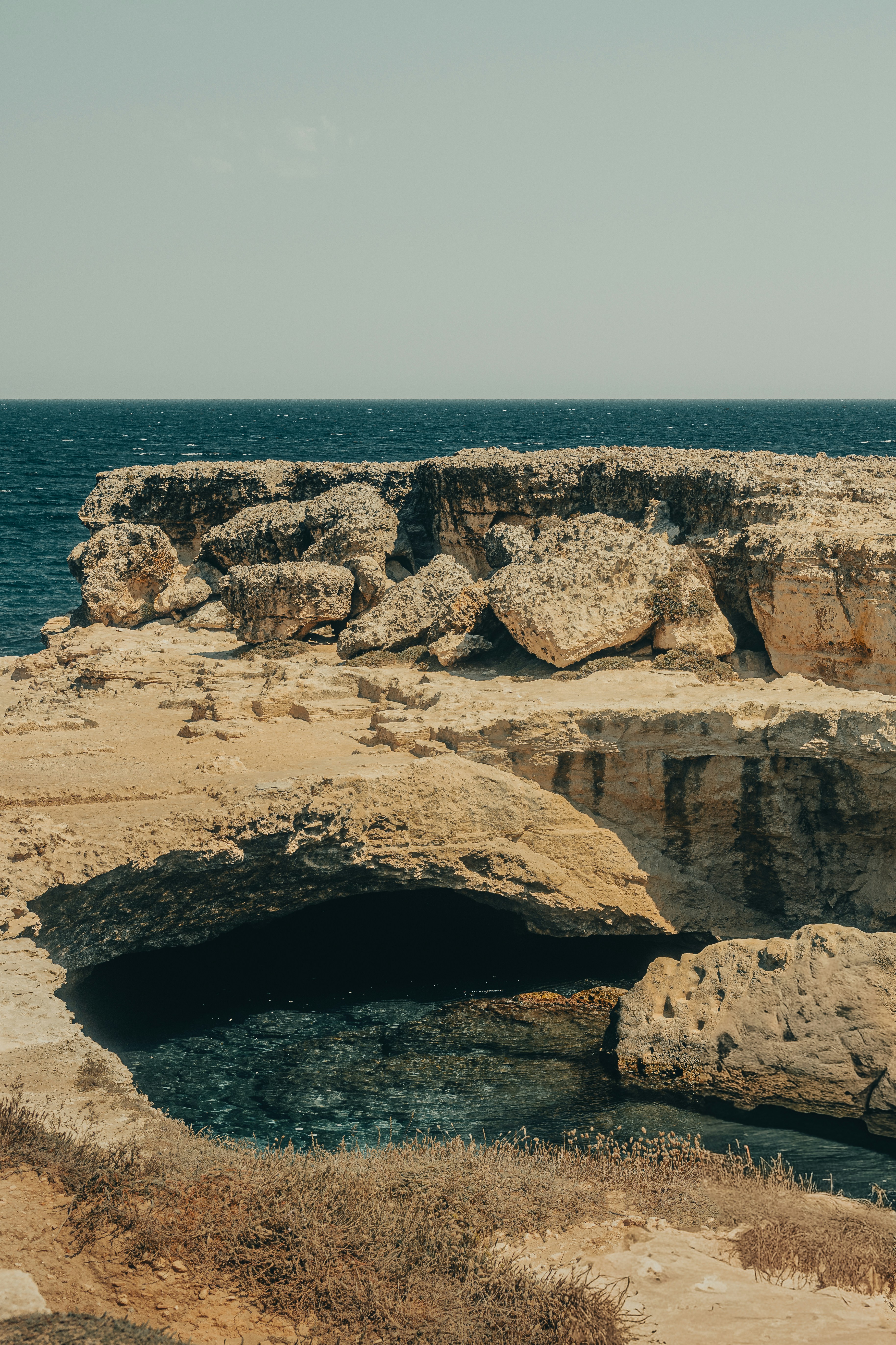 Sea Cave at Dusk: Weathered Rock Boneyard Overlooking a Quiet Ocean